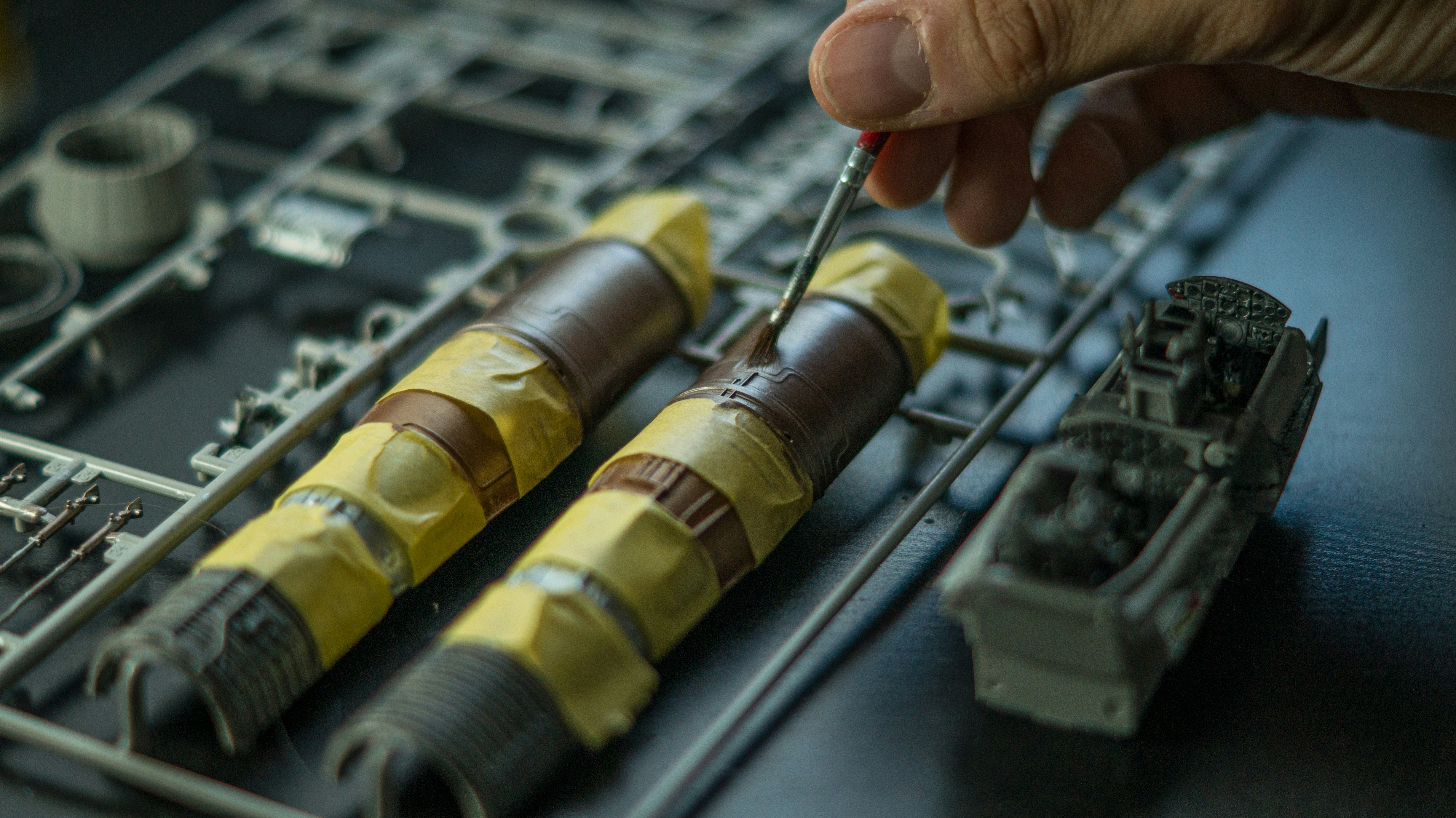 Tape-Wrapped Cylinders on a Model Engine Sprue: A Tiny Hand at Work