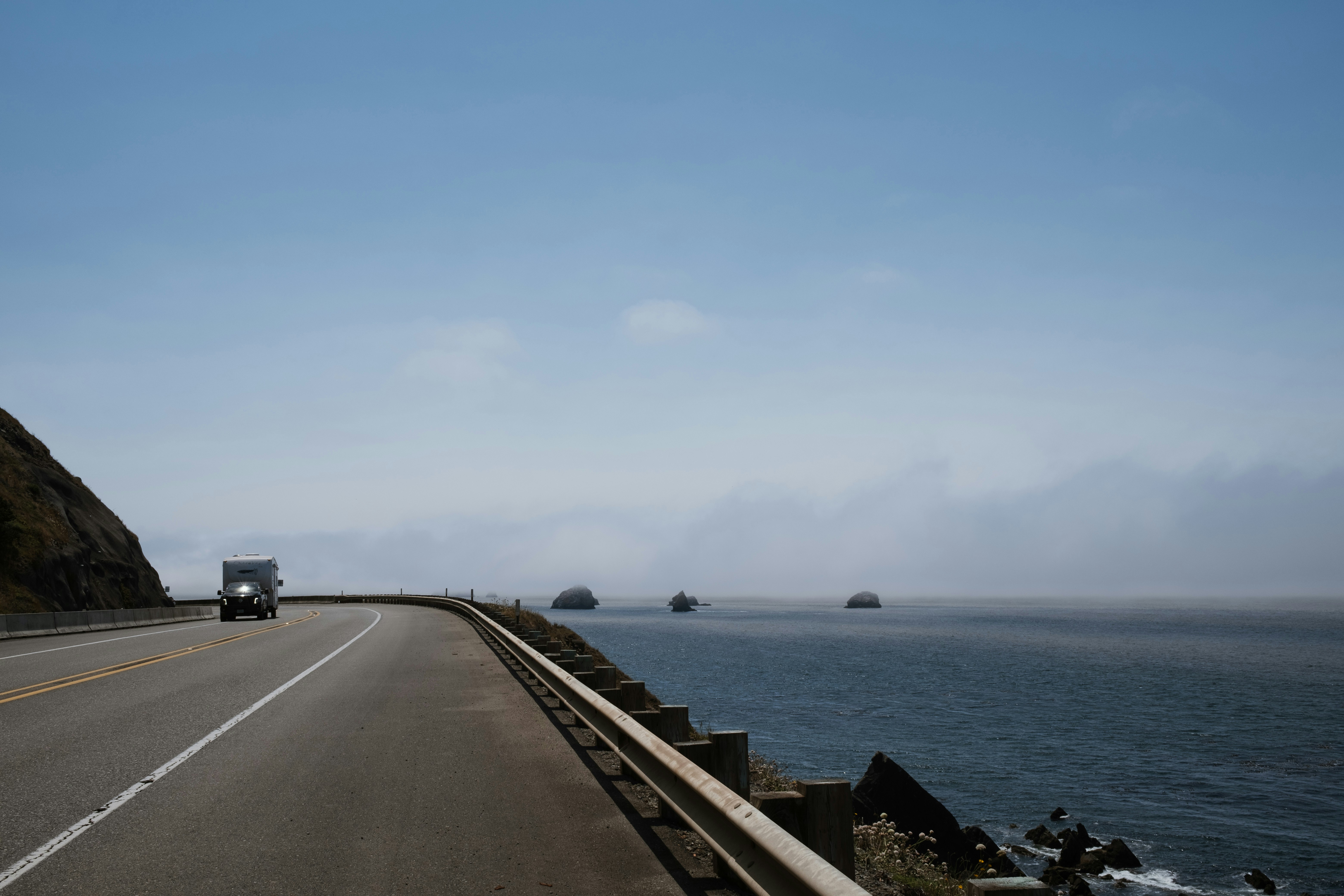 Coastal Curve: A Lone Vehicle on the Quiet Sea Road
