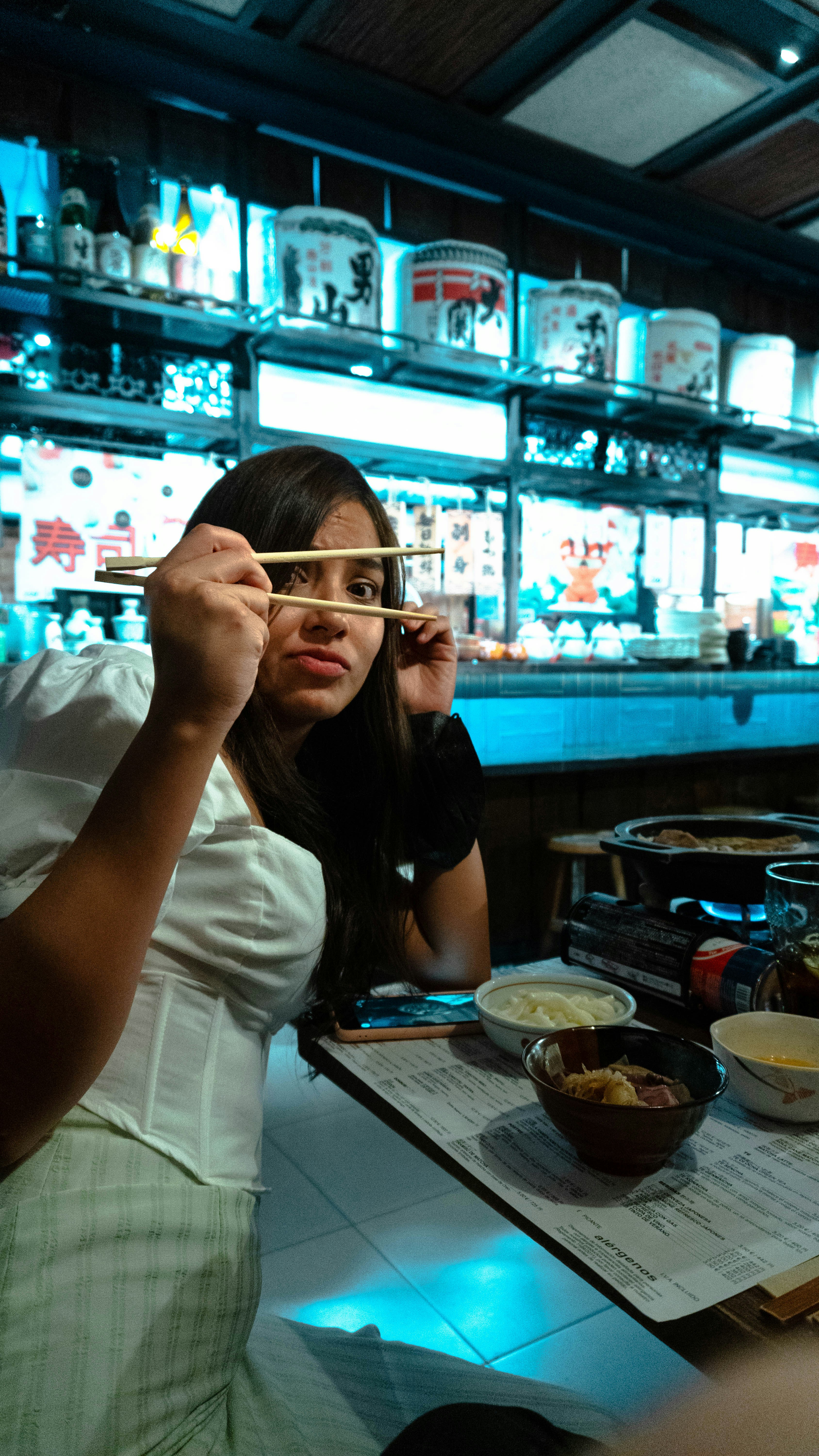 Chopsticks Under Neon: A Quiet Moment in a Sushi Bar