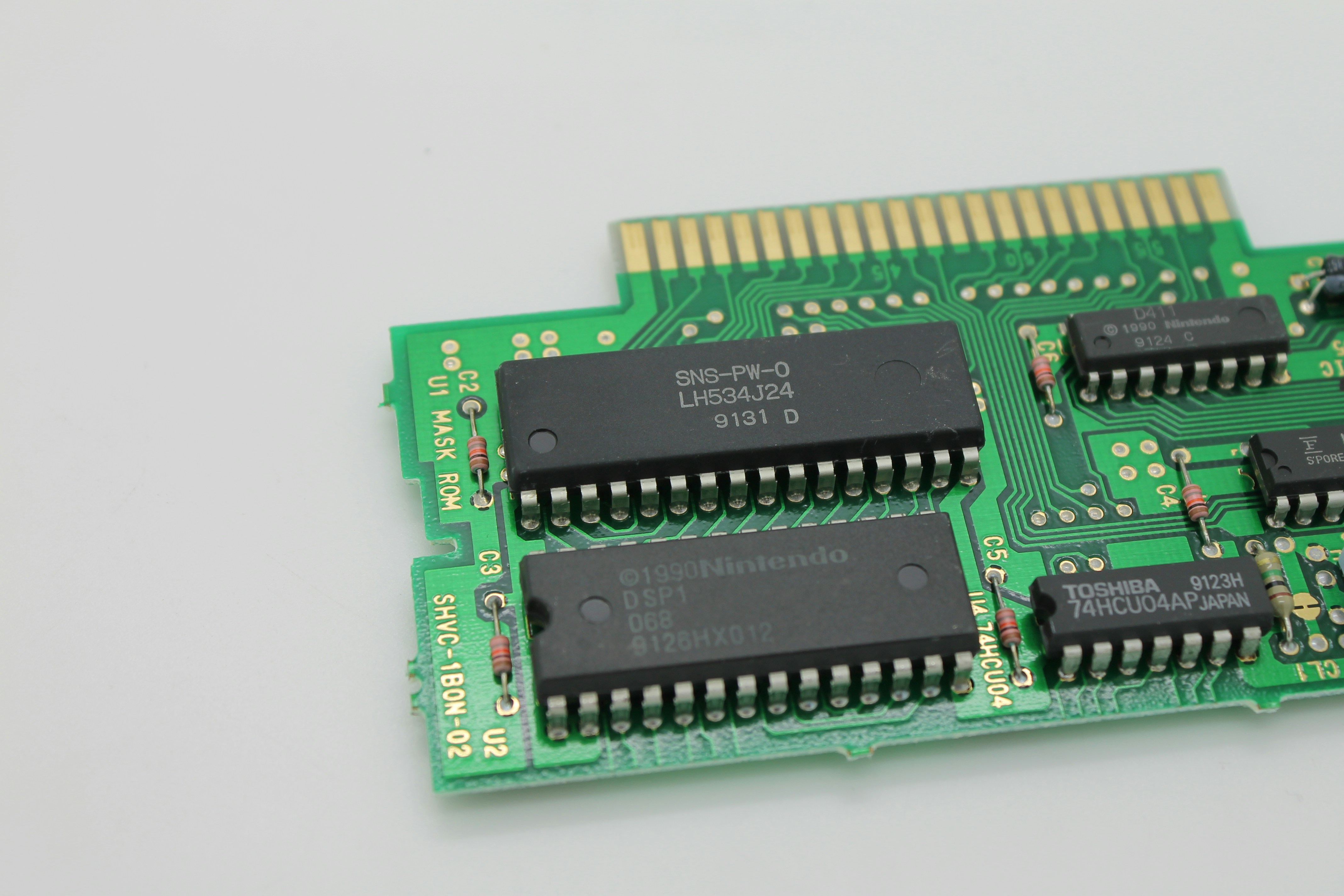 Close-up of a printed circuit board featuring vintage chips, showcasing intricate pathways and connections. A glimpse into the technology behind classic gaming consoles.