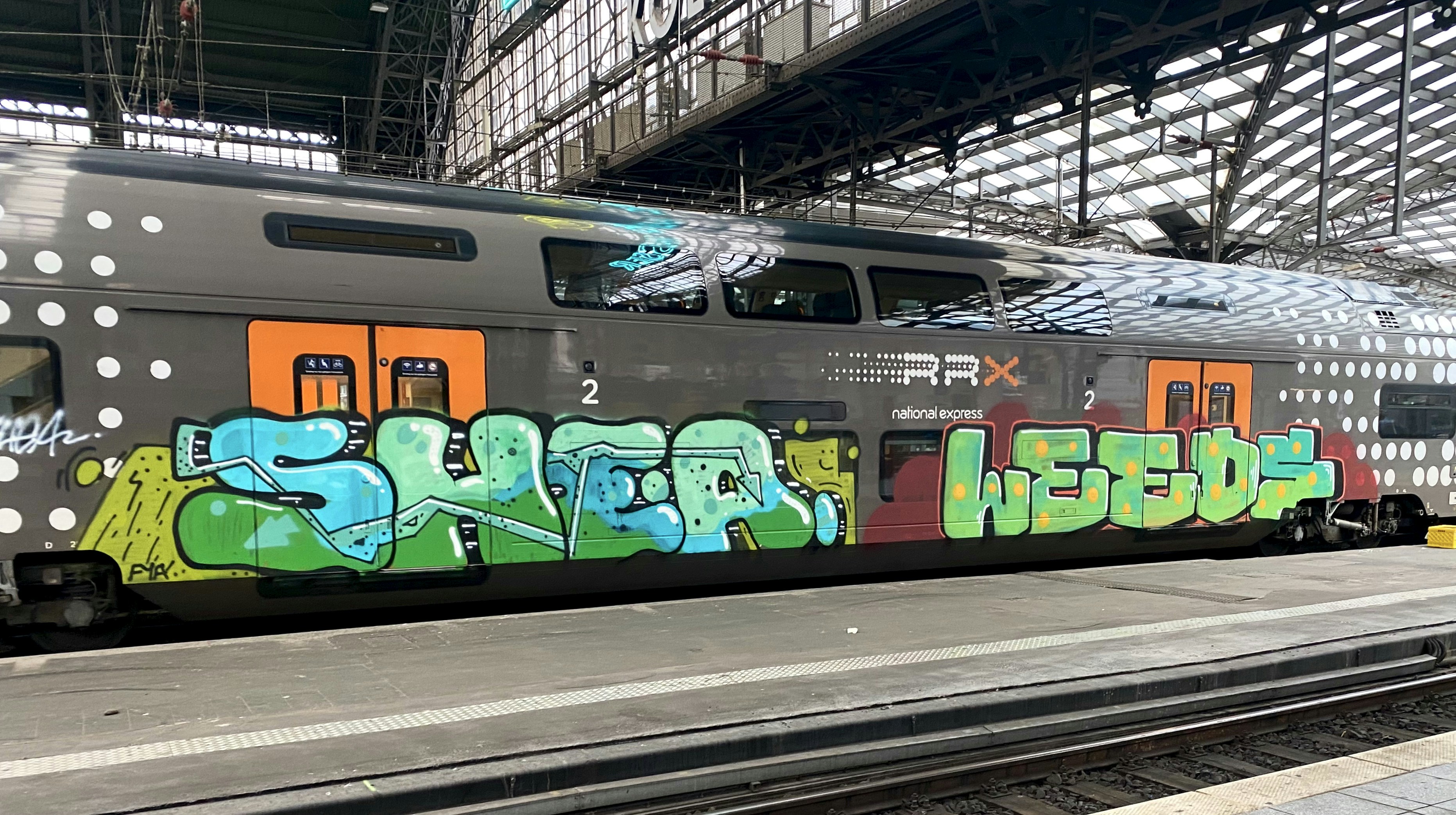 Urban Canvas on Rails: Graffiti-Adorned Train at Platform