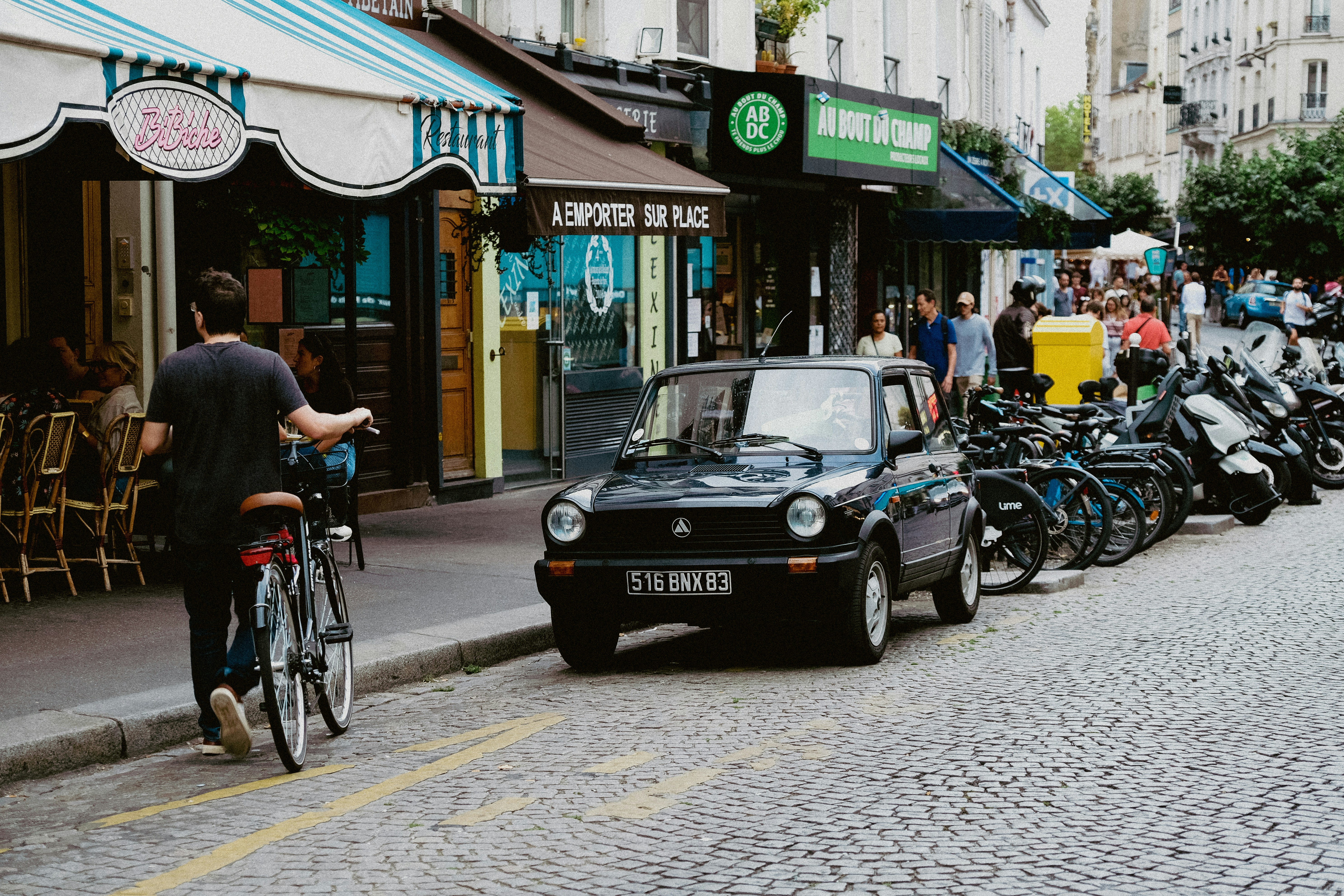 A person riding a bicycle next to a car parked on the side of a street ...