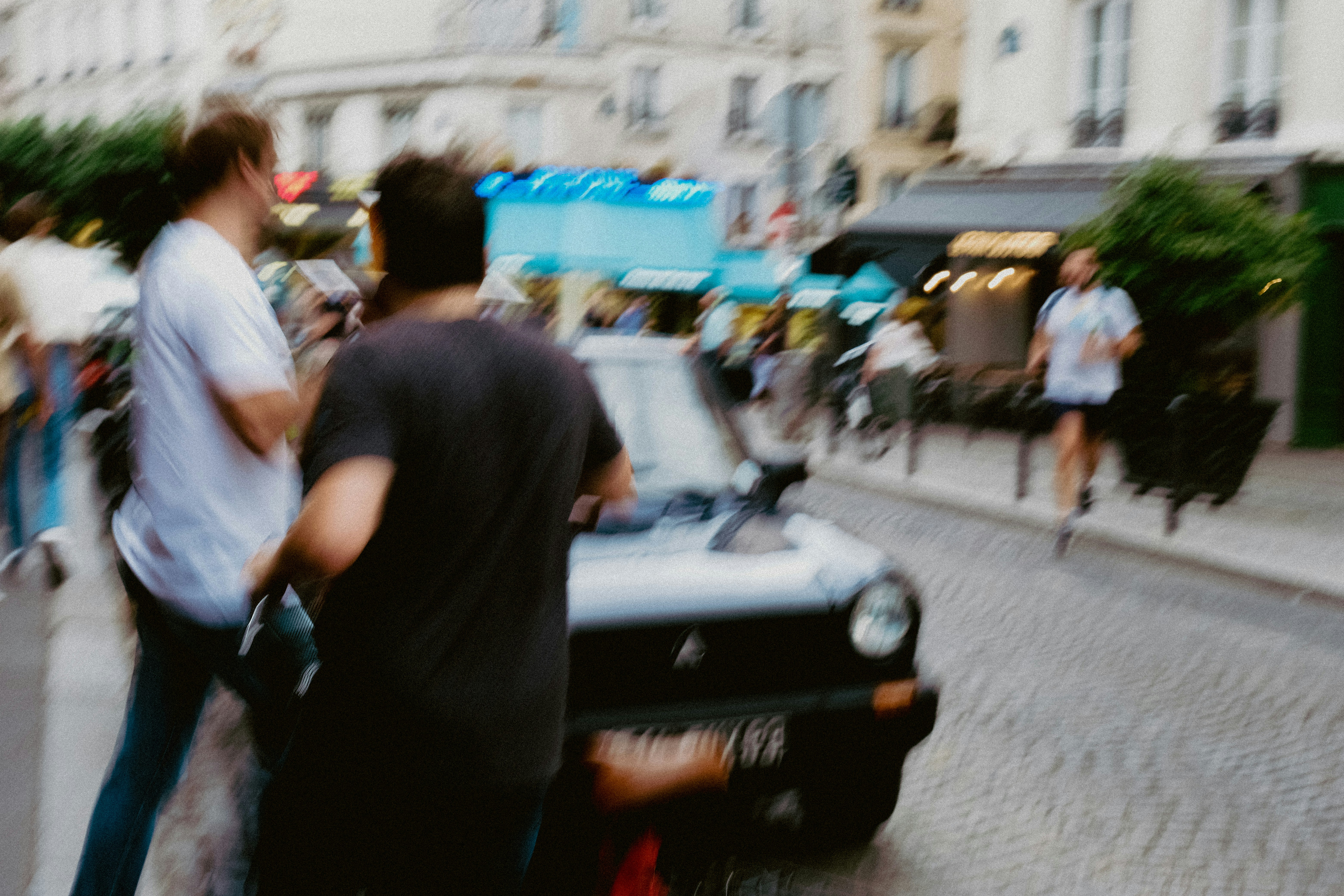 Cobblestone Blur: A Car Anchored in a Moving City Square