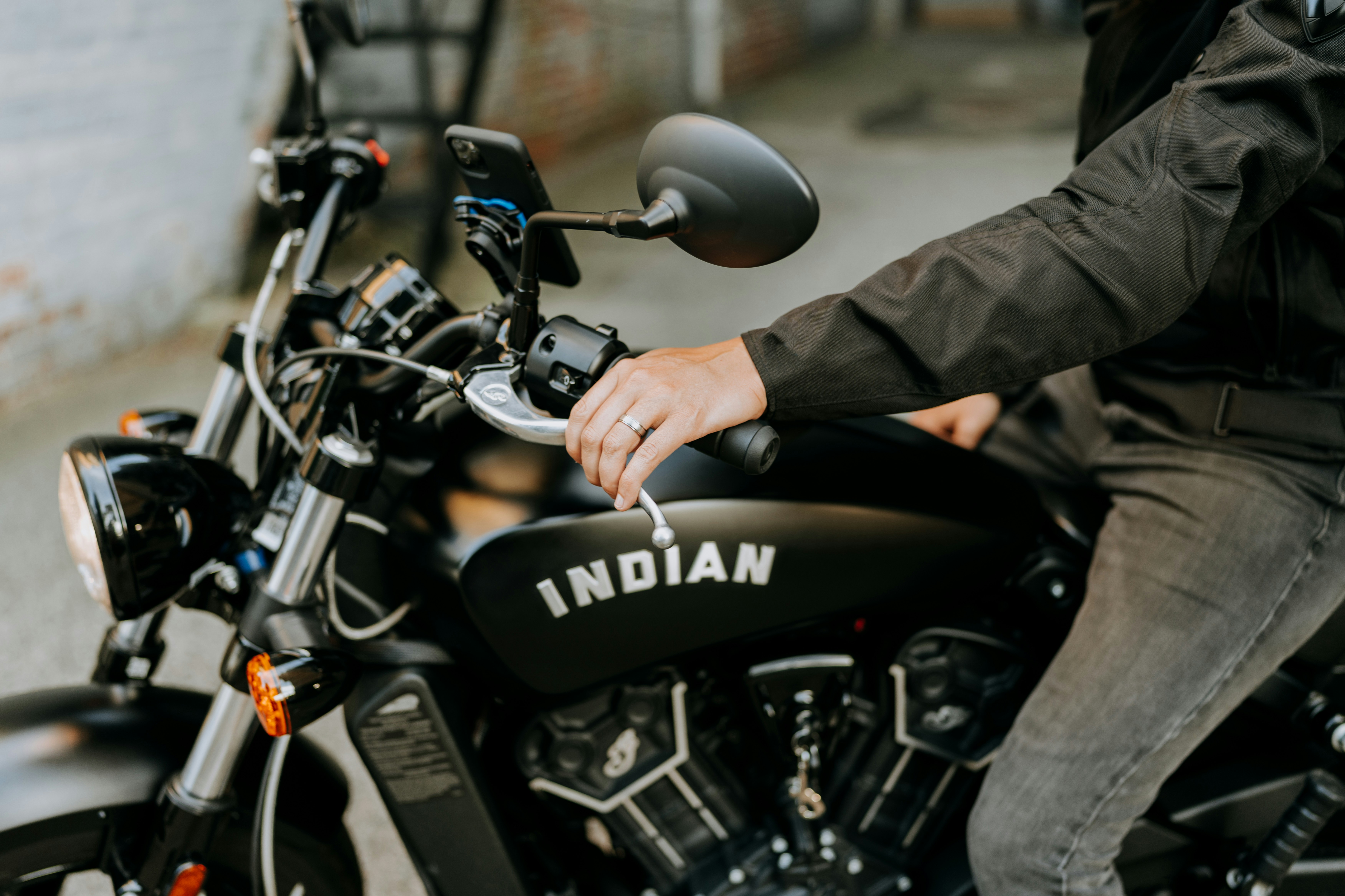 Understated Power: A Rider’s Hand Resting on a Matte Indian