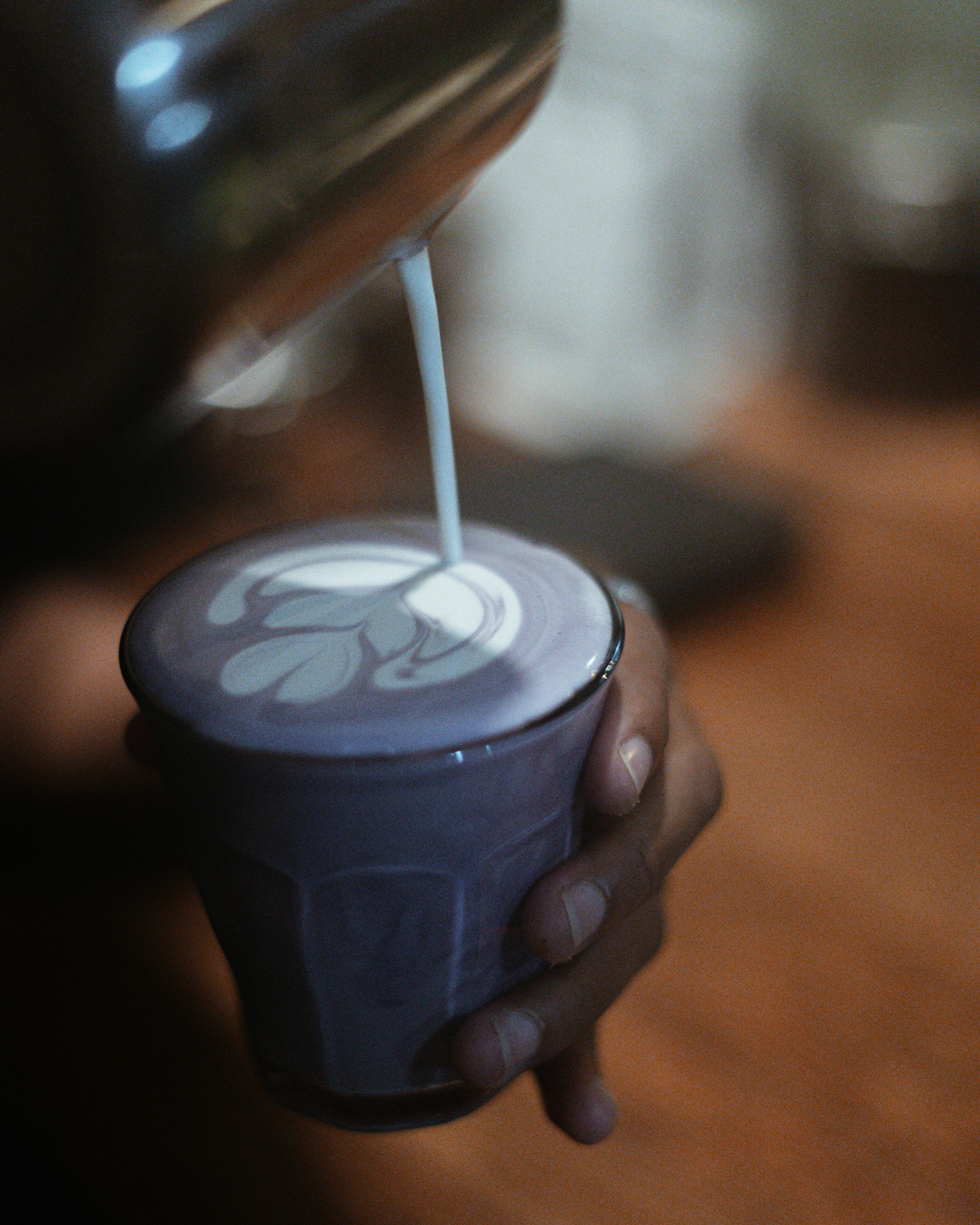 Rosette in Hand: Milk Pour Creates Latte Art in a Purple Cup