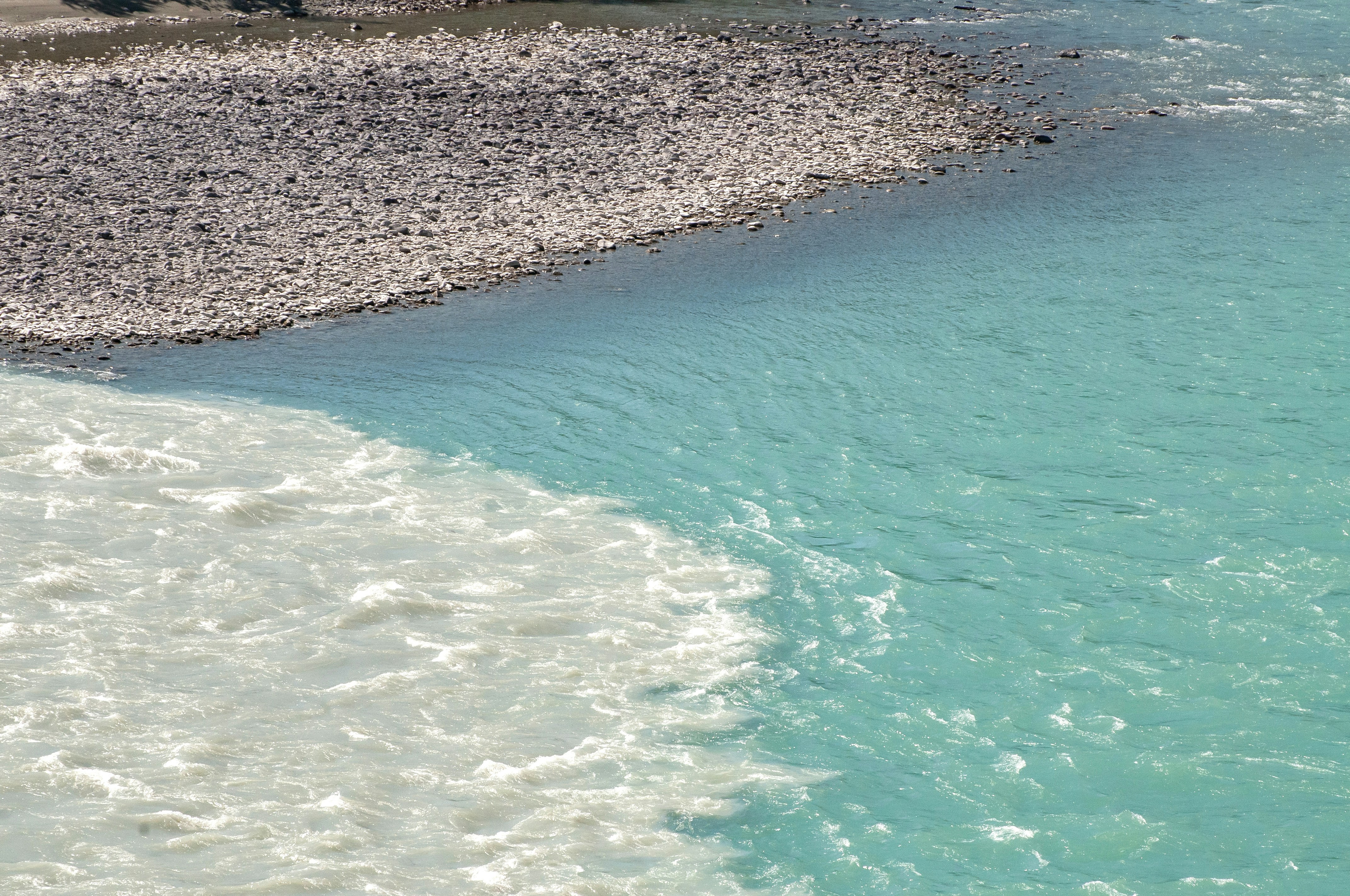 A body of water with rocks and a beach in the background photo – Free ...