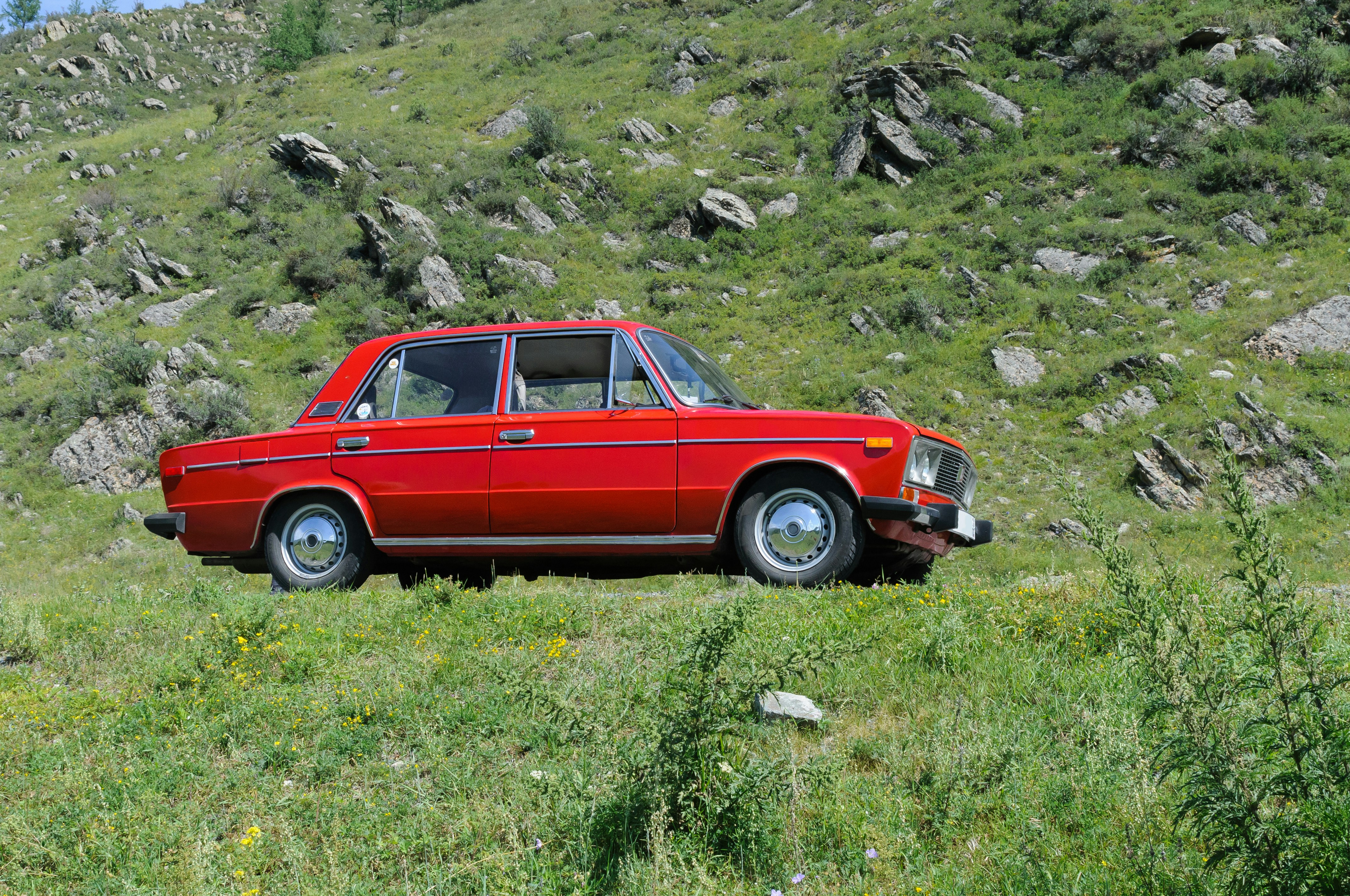 A red car parked on a rocky hillside photo – Free Travel Image on Unsplash