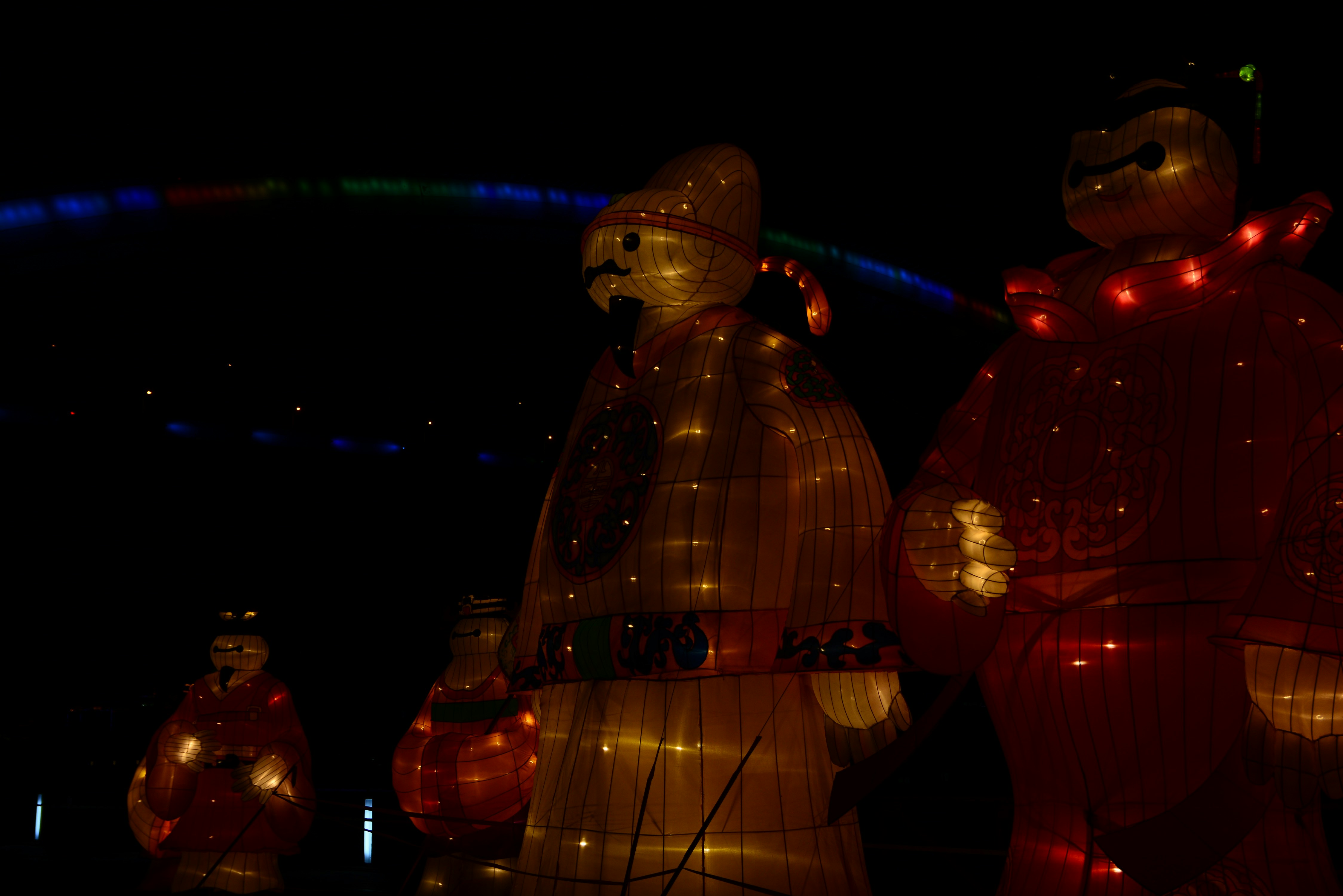 Nocturnal Parade: Inflatable Snowmen Illuminated in a Dark Night