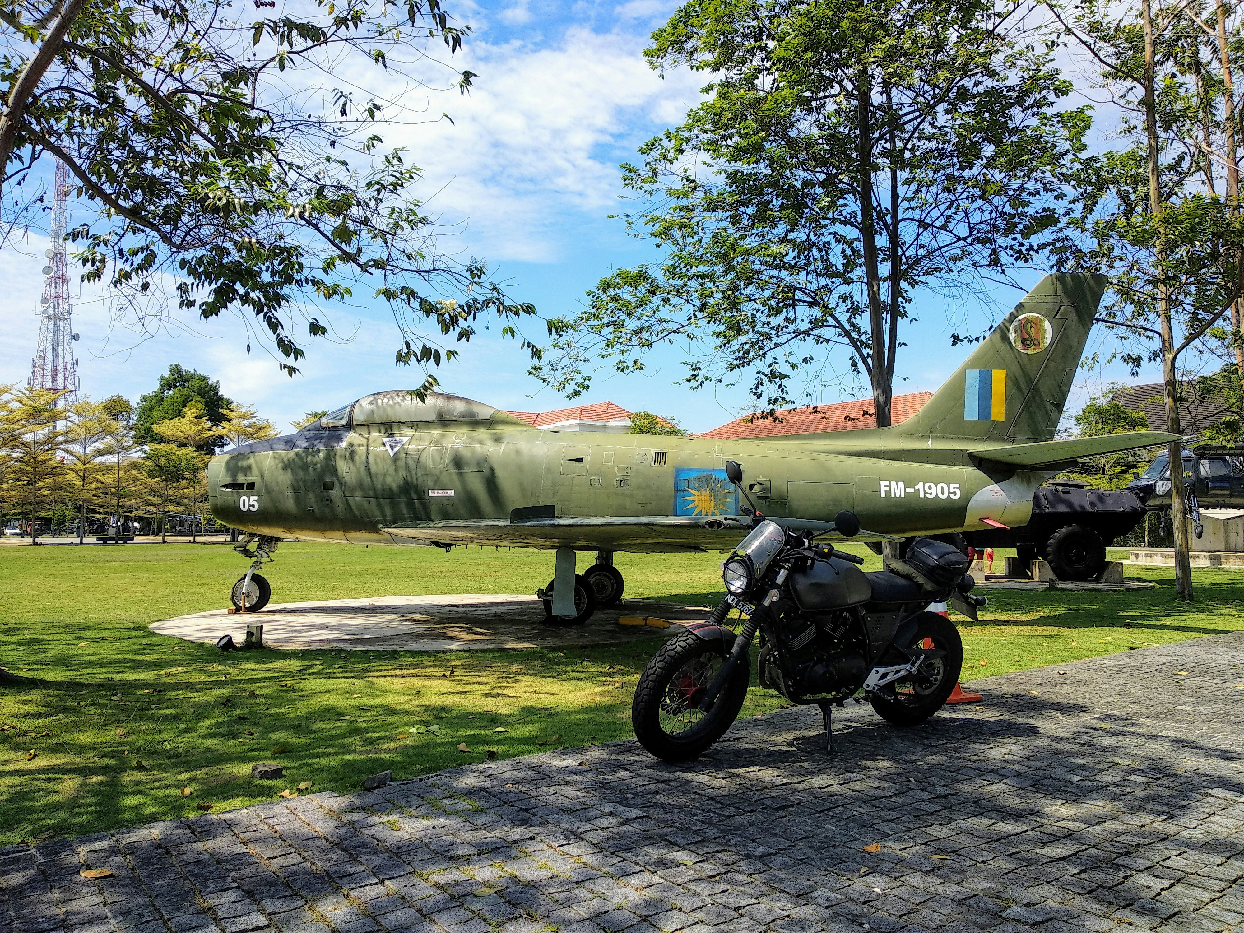 A motorcycle parked next to a military plane photo – Free Fighter jet Image on Unsplash