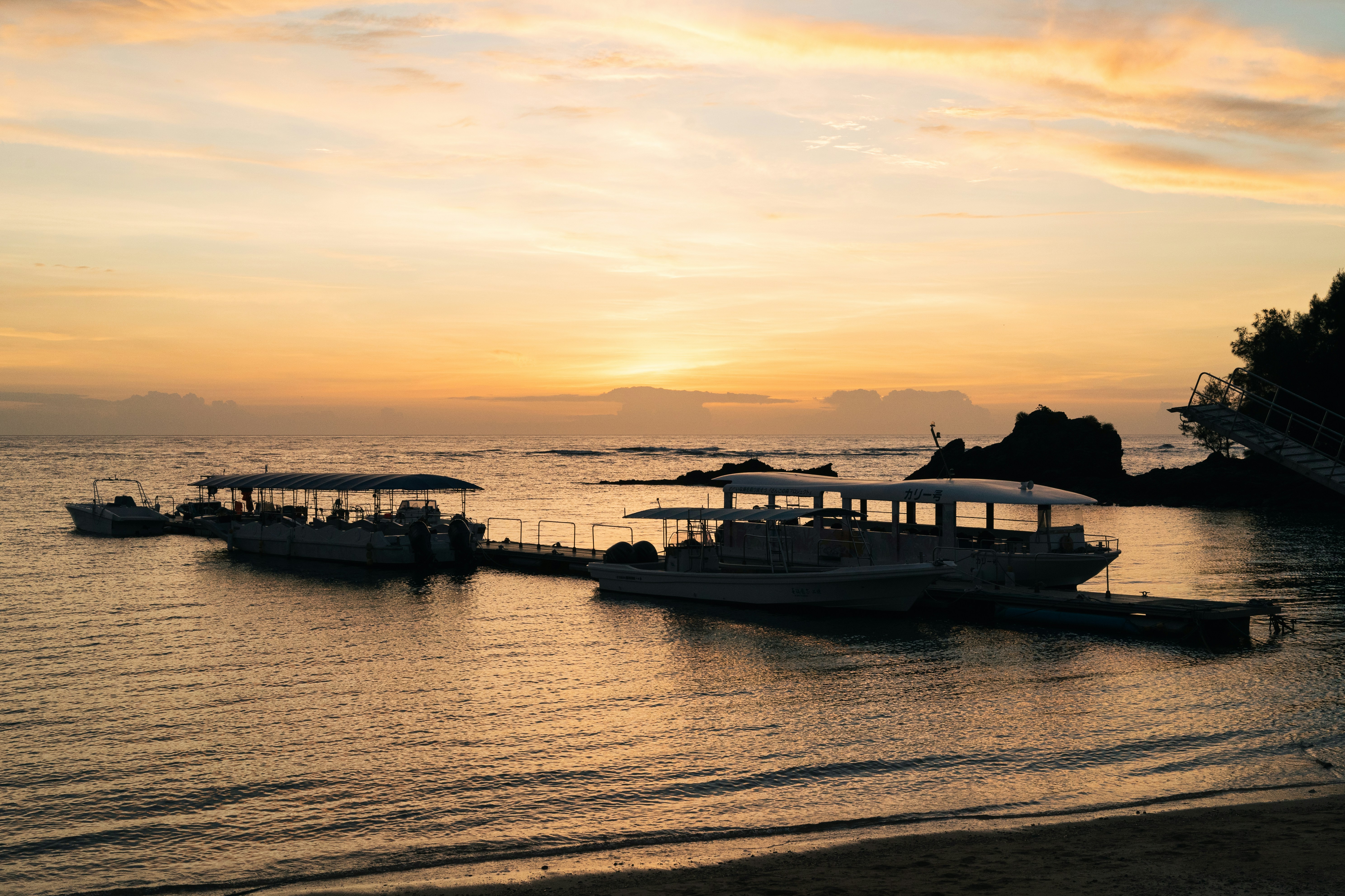 Sunset Over a Quiet Cove: Boats Moored Against a Glowing Horizon