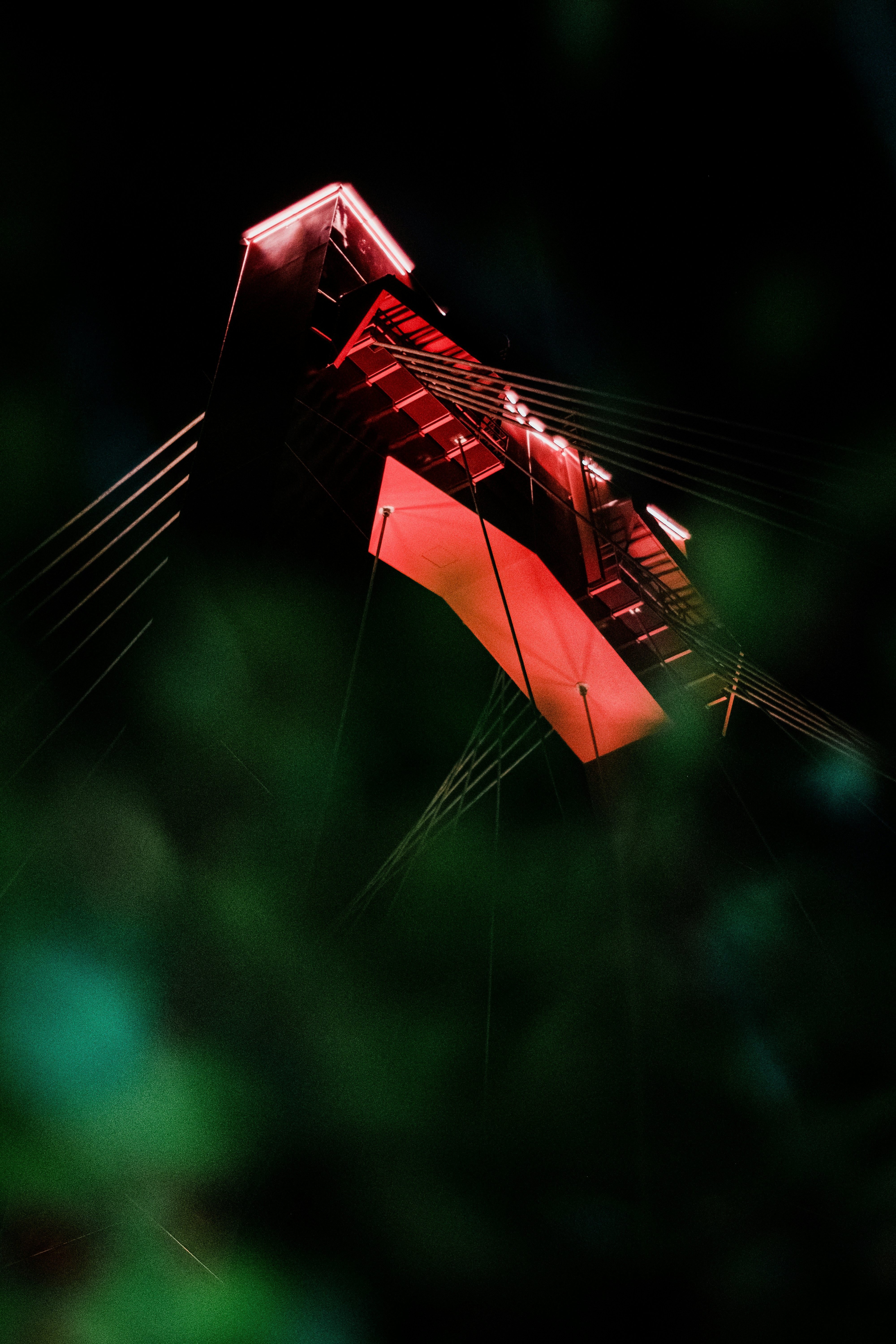 Crimson Tower in the Night: Neon Cables Framing a Velvet Dark