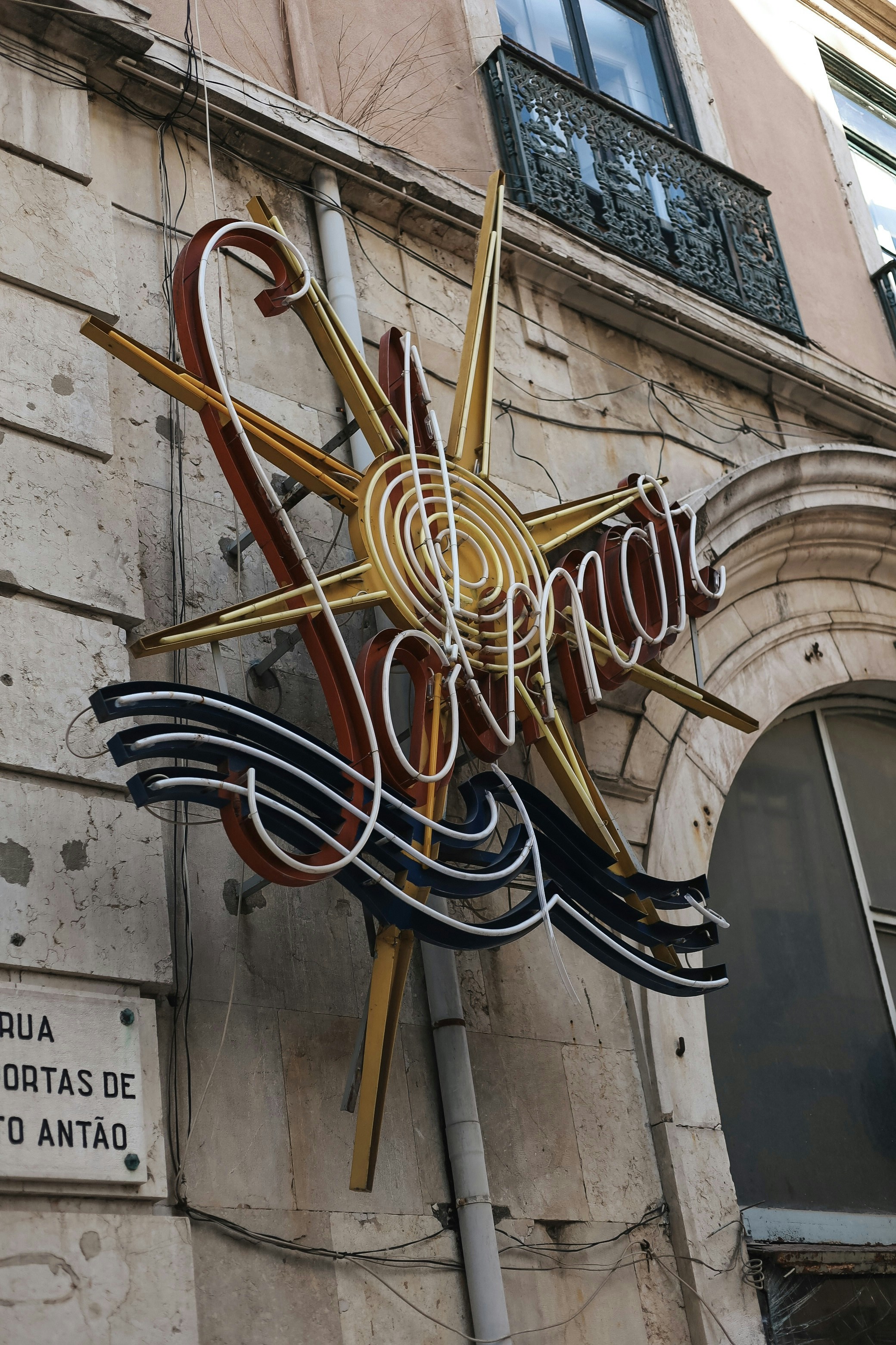 Neon Sunburst Above a Weathered Façade