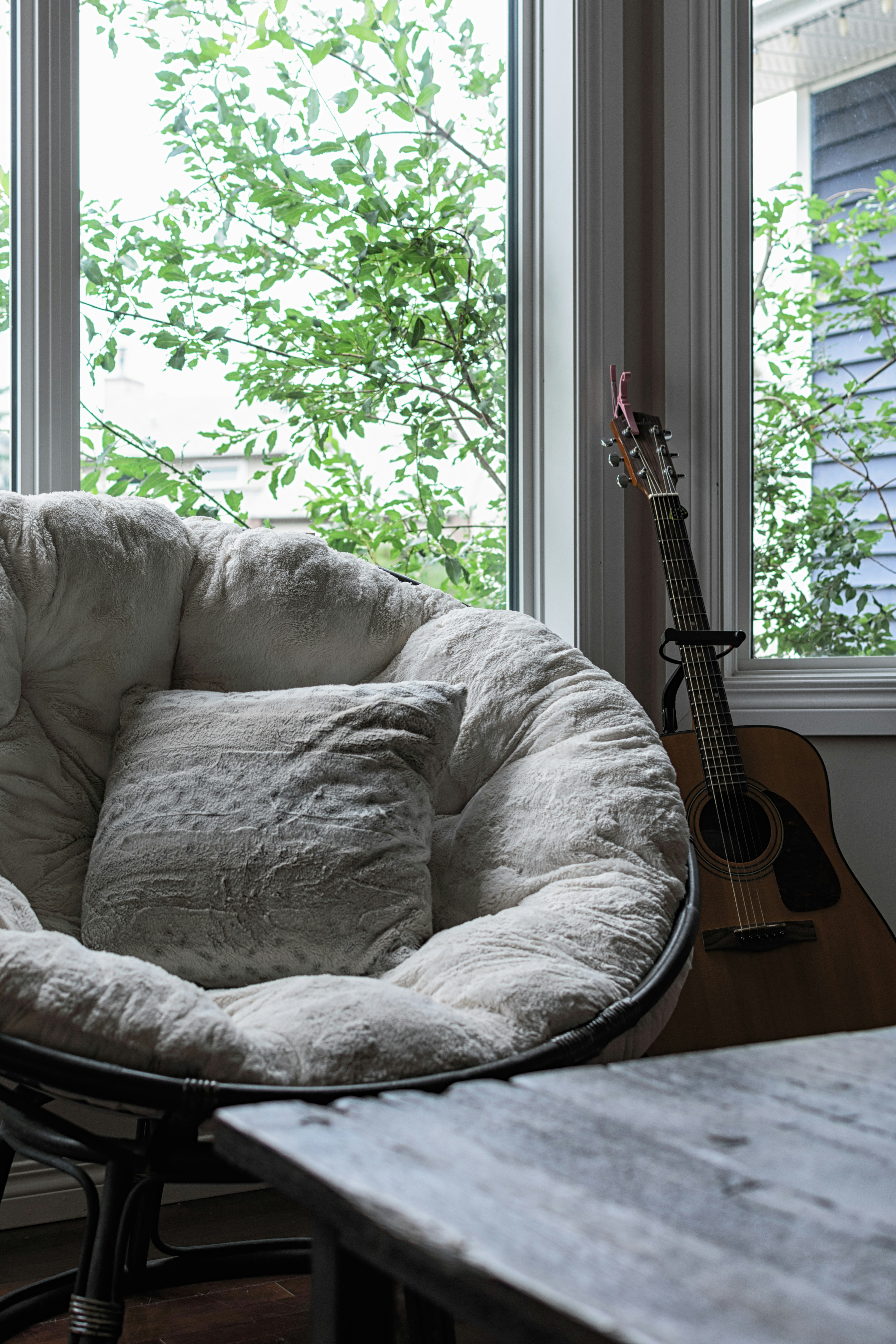 Quiet Corner: A Plush Papasan, Acoustic Guitar, and Window View