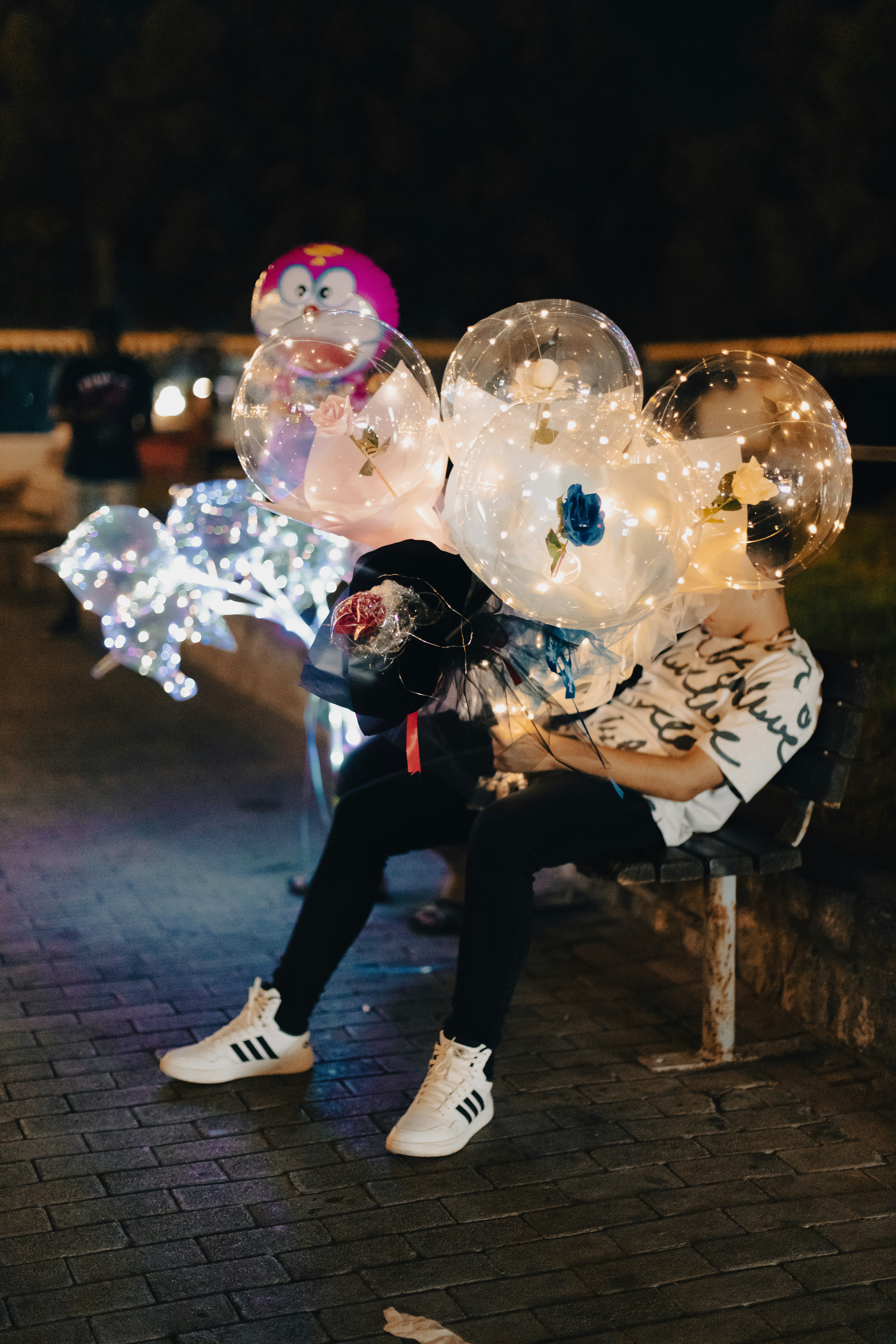 Glowing Street Characters: Balloons, Lights, and Night Bench