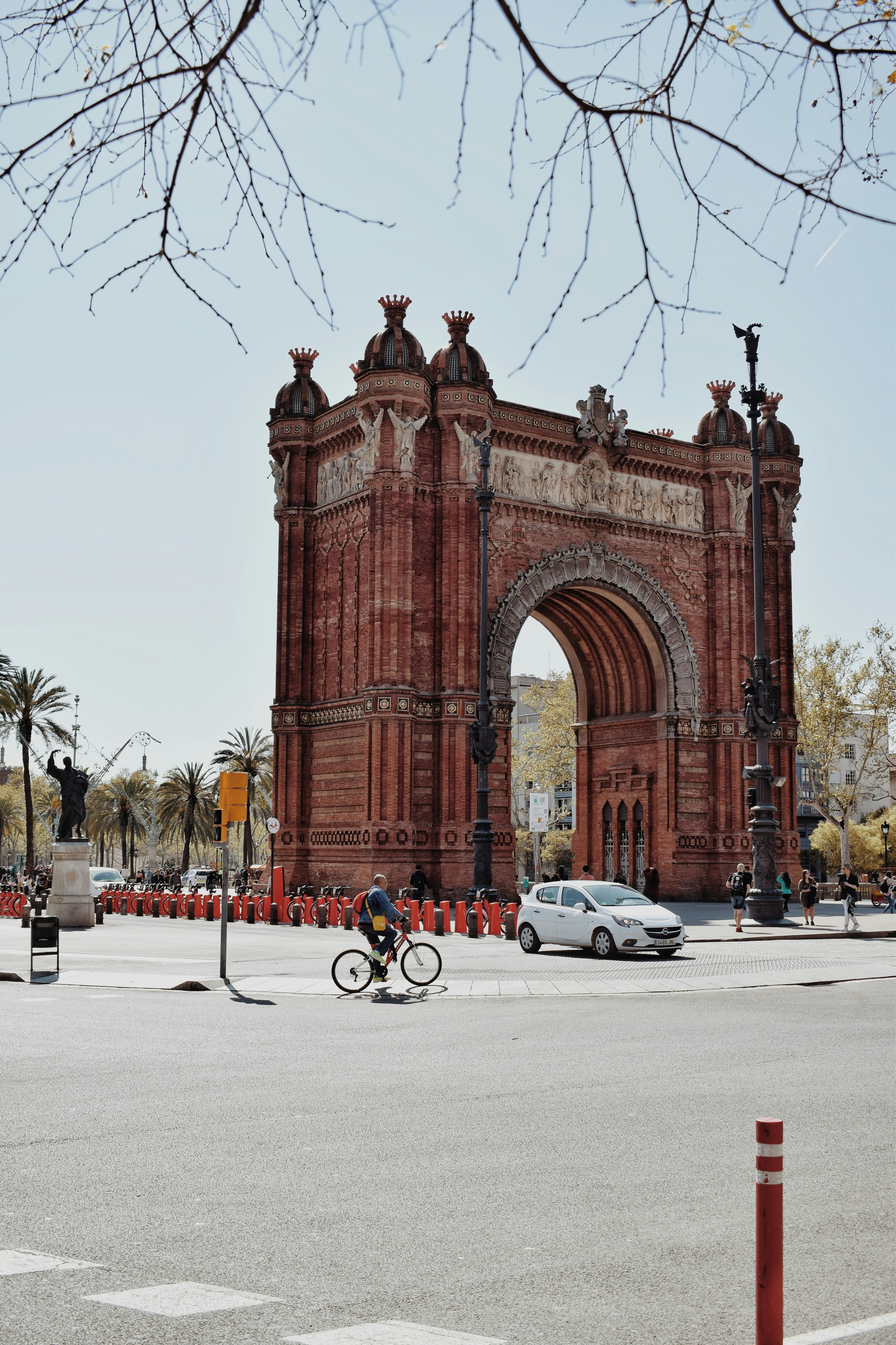 Brick Arch, City in Motion: Barcelona's Arc de Triomf at a Bustling Roundabout