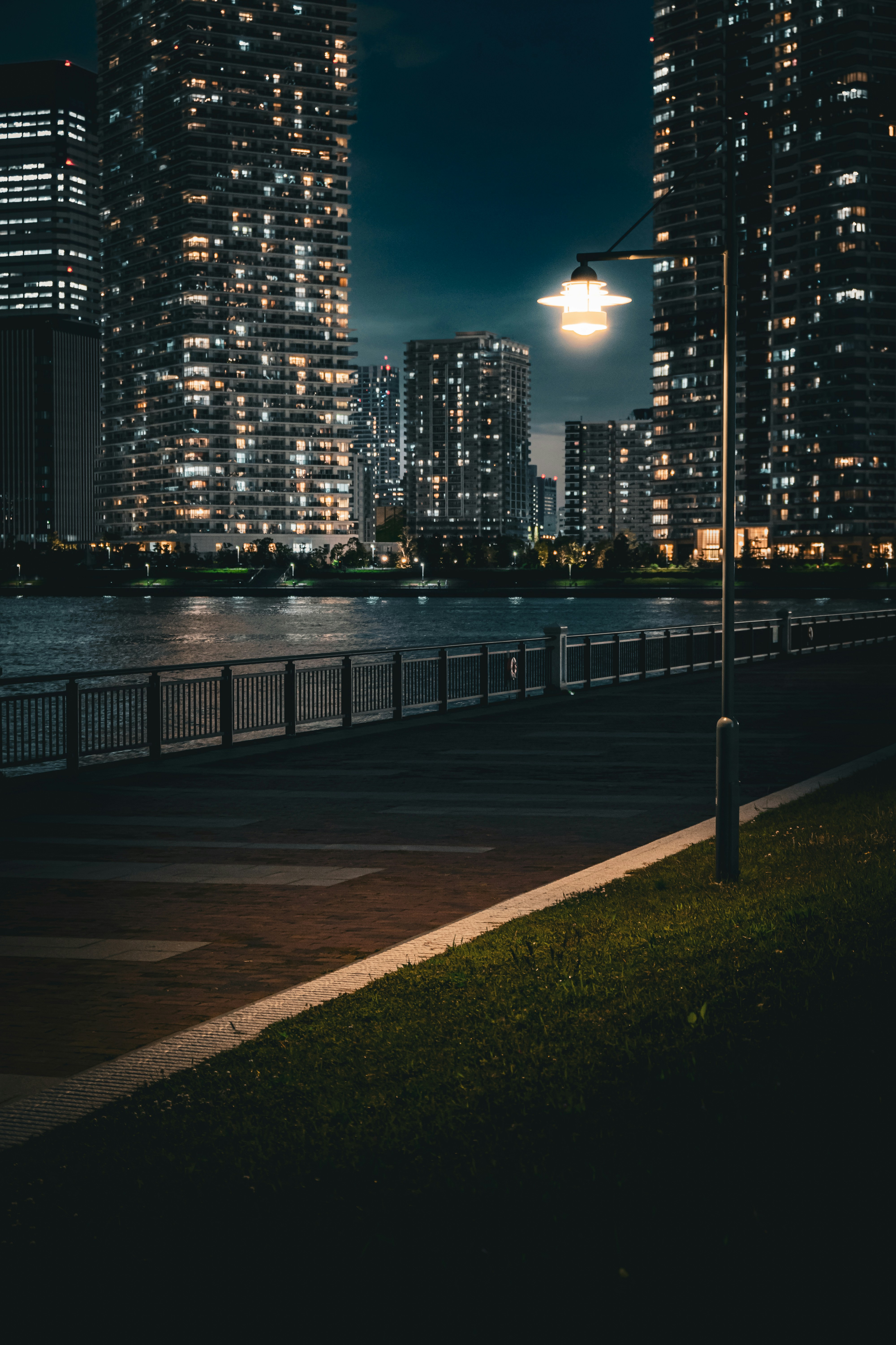 Night Lantern Over the Riverfront: City Lights Framing a Quiet Walk