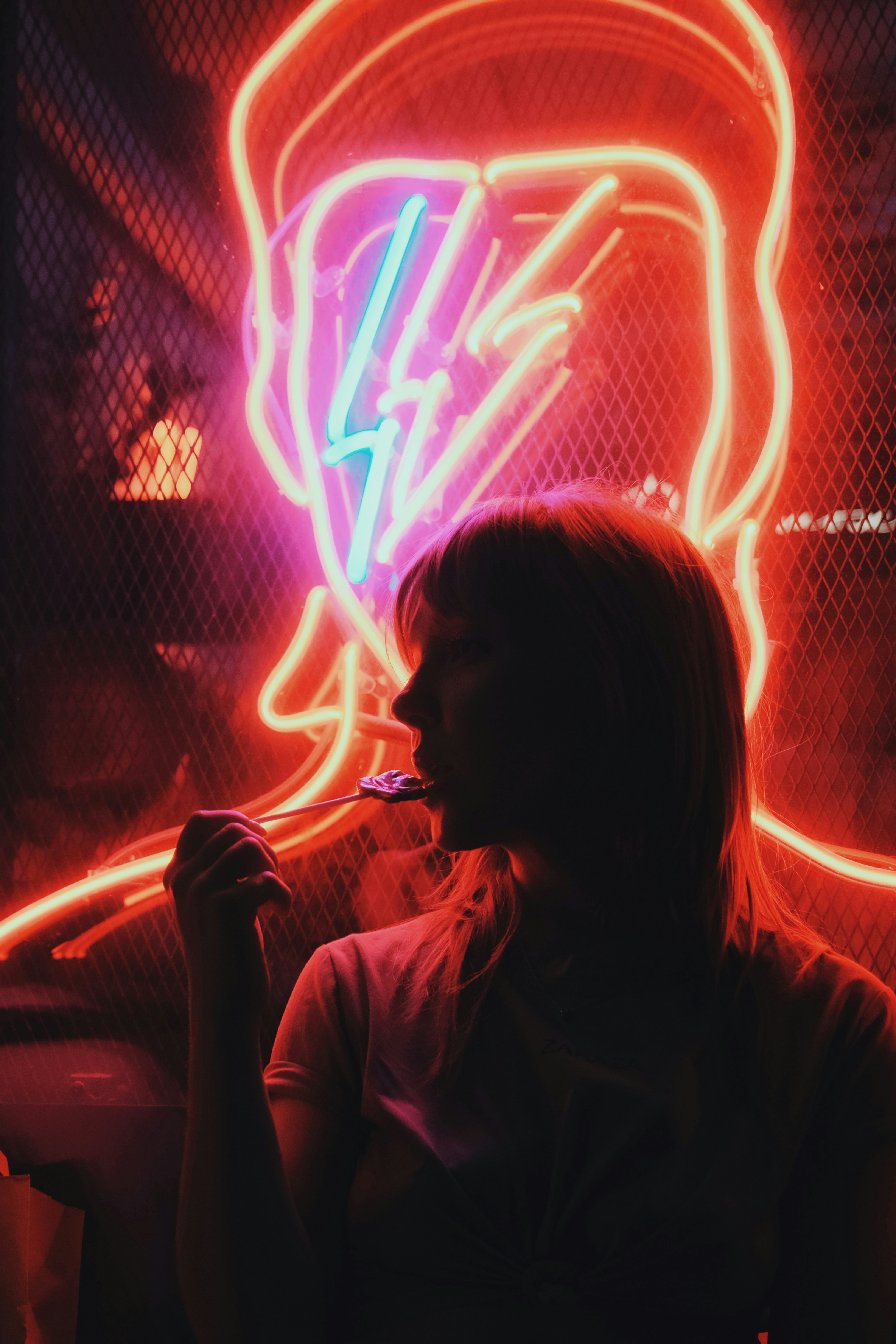 Neon Silhouette: A Quiet Bite Amid Electric Veins