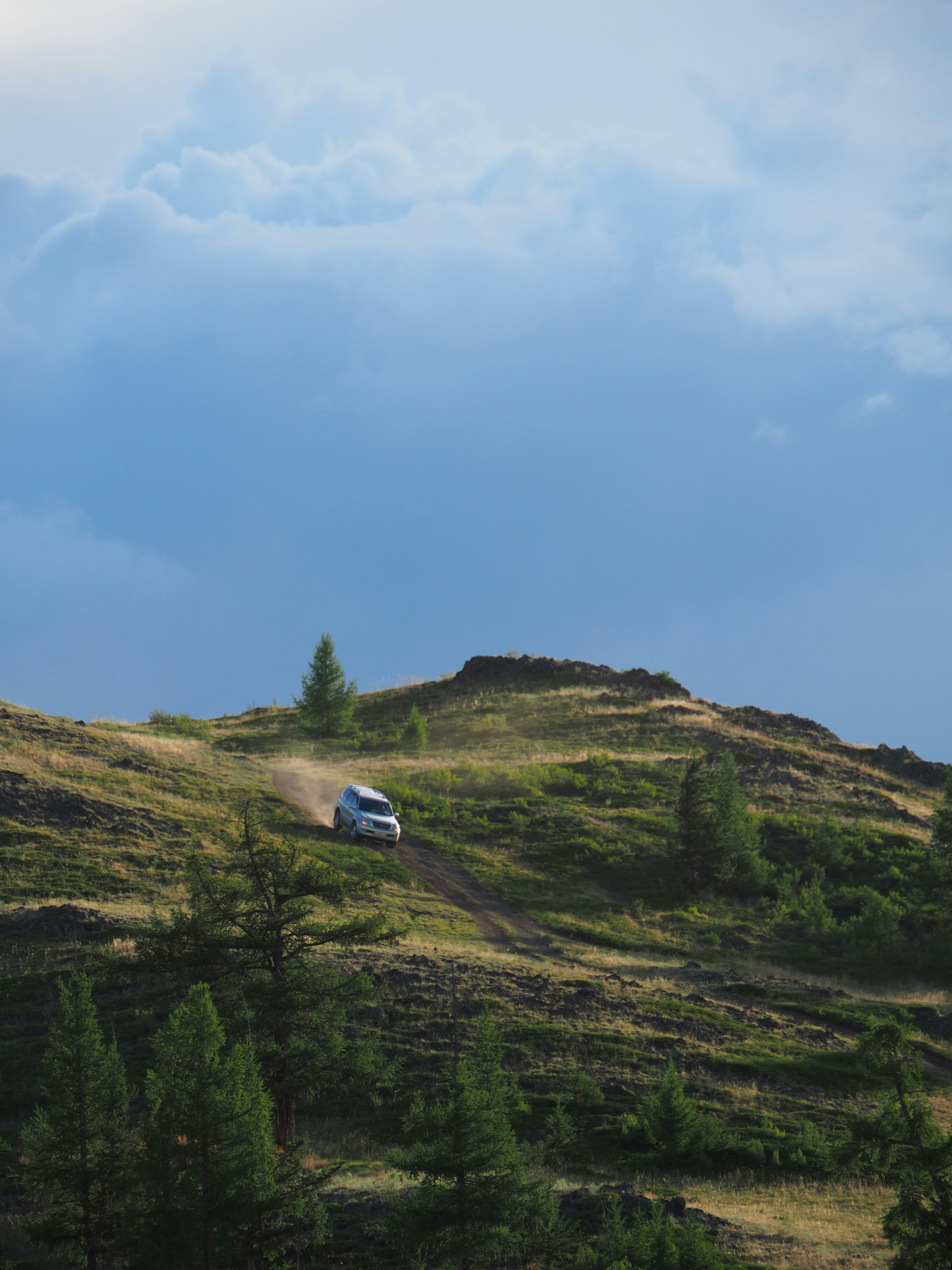 A car driving on a road in a hilly area photo – Free Nature Image on ...
