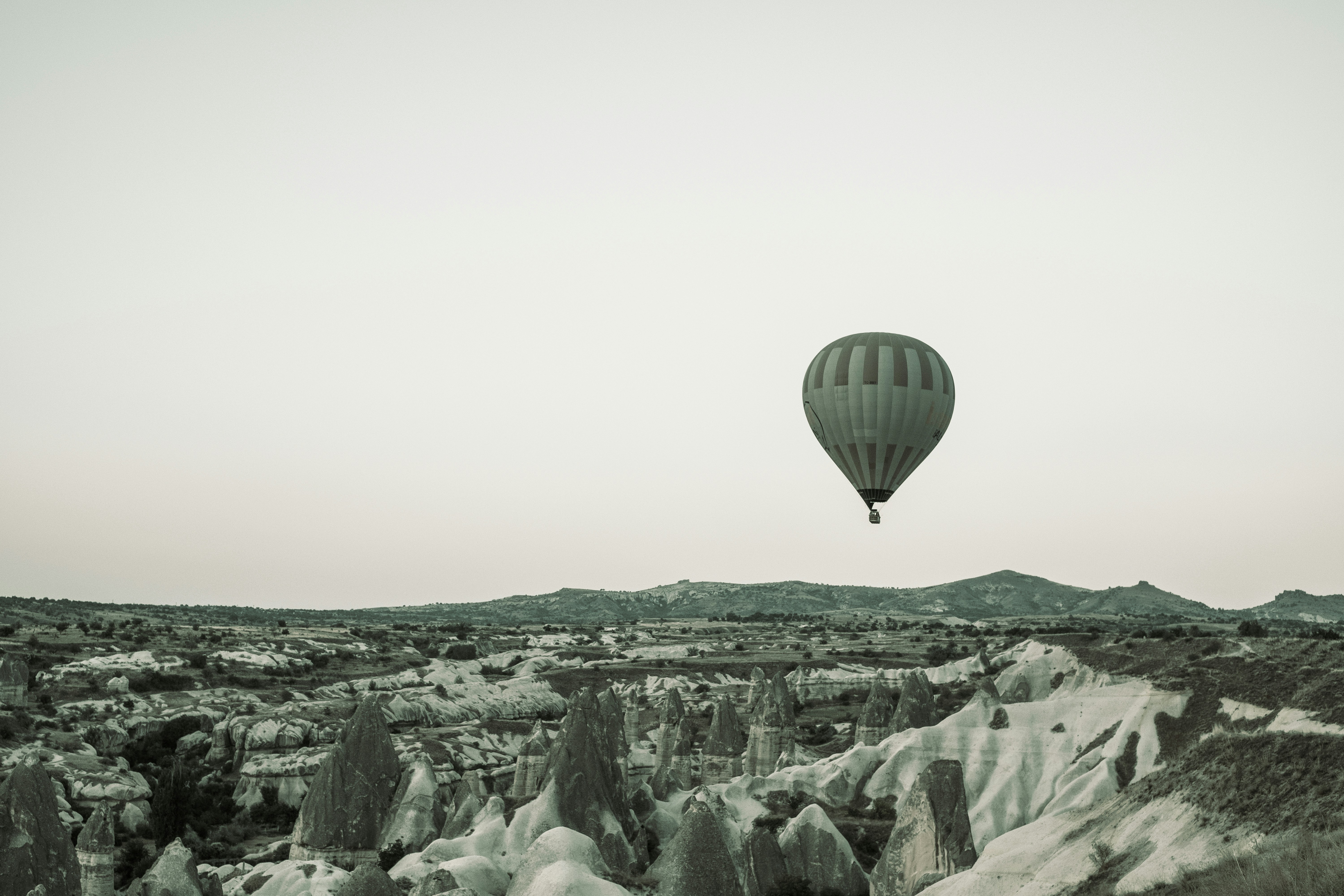 A hot air balloon flying over a rocky landscape photo – Free Turkey ...