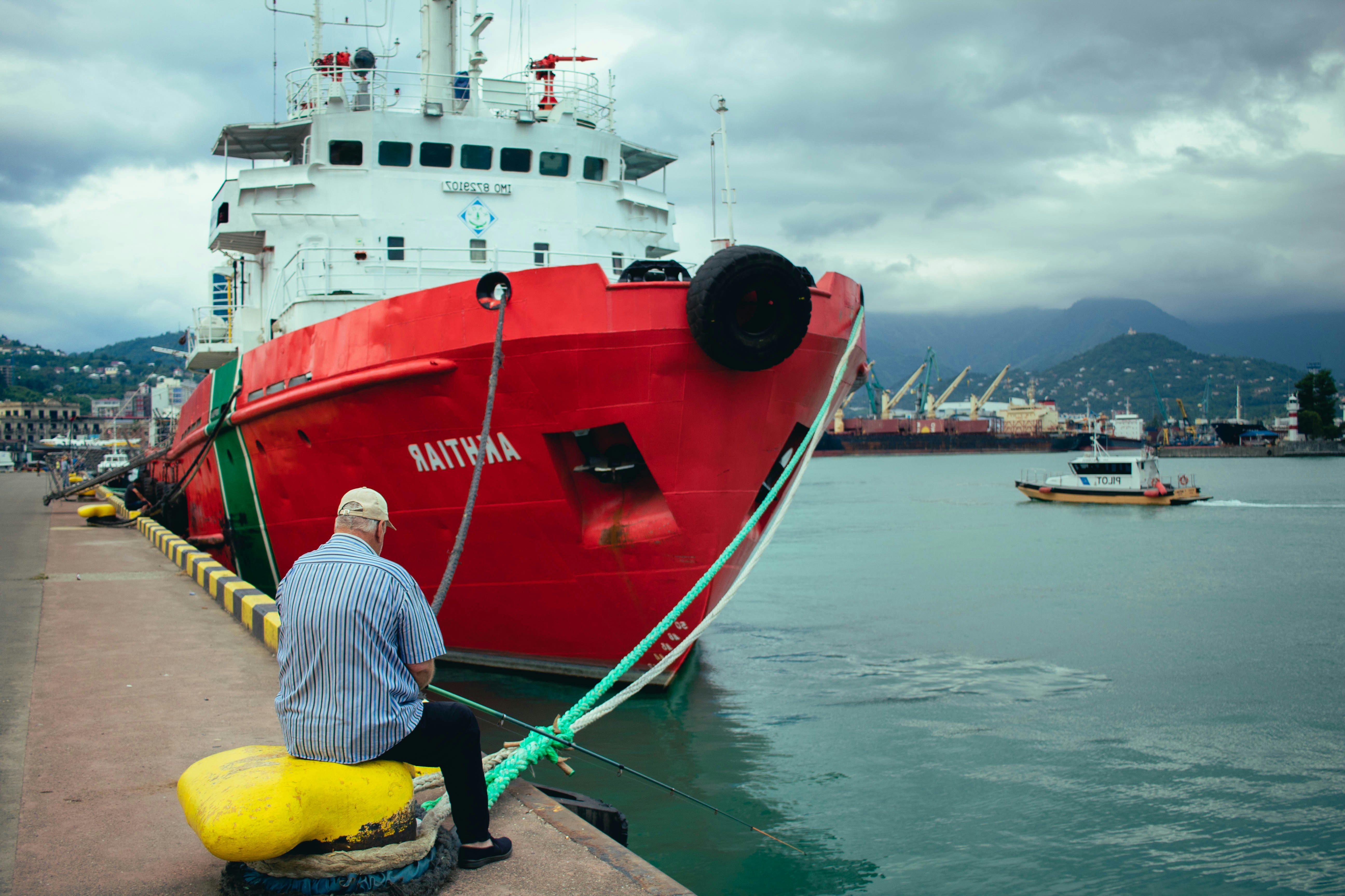 Anchor of Routine: A Seafarer and the Red Vessel at Wharf
