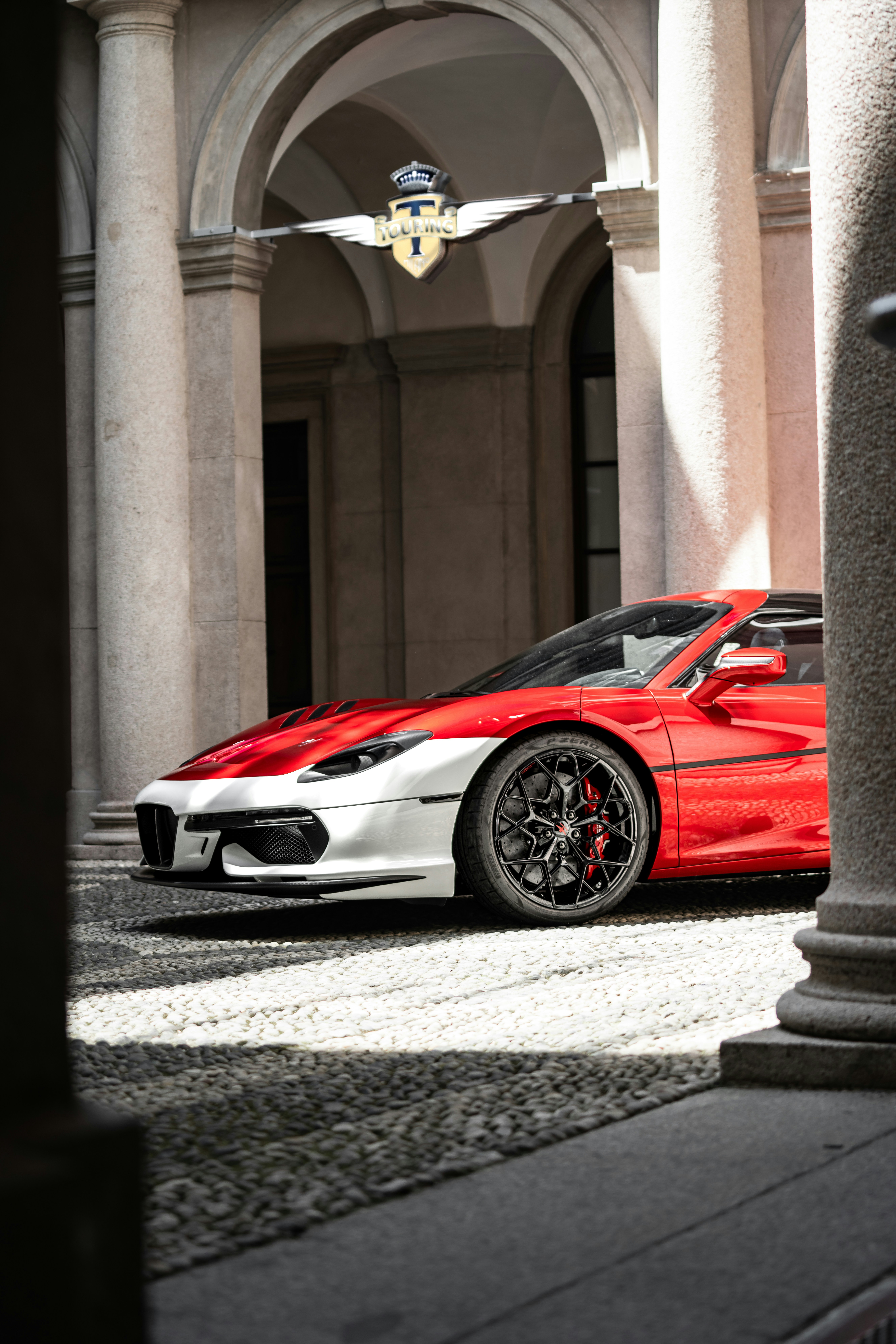 Two-Tone Hypercar Nestled Between Ancient Arches in a Sunlit Courtyard