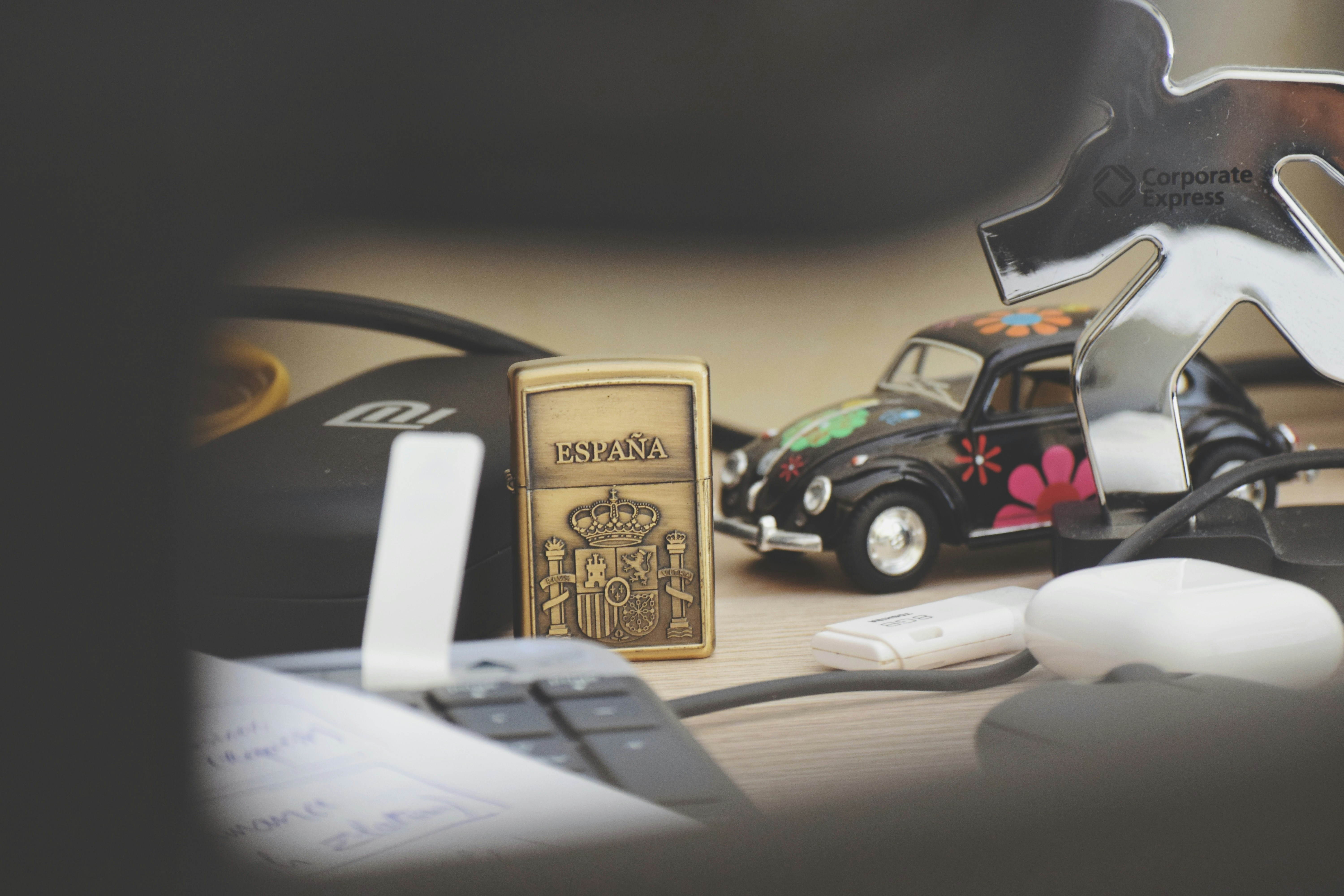 A decorative Spain-themed emblem sits alongside a colorful toy car and office supplies, encapsulating a blend of culture and daily life.