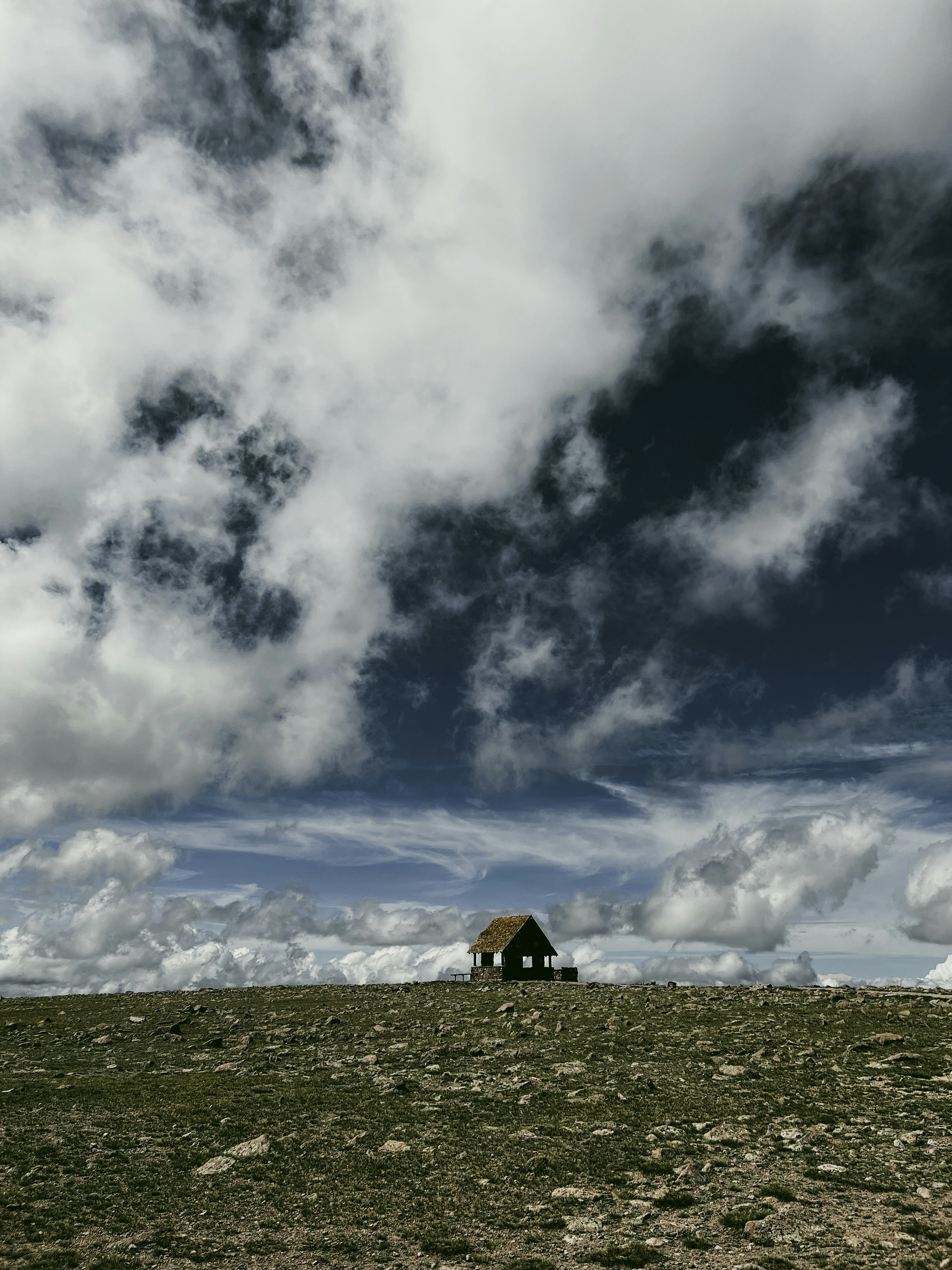Thatched Cabin on a Wind-Swept Plateau Beneath a Monumental Sky
