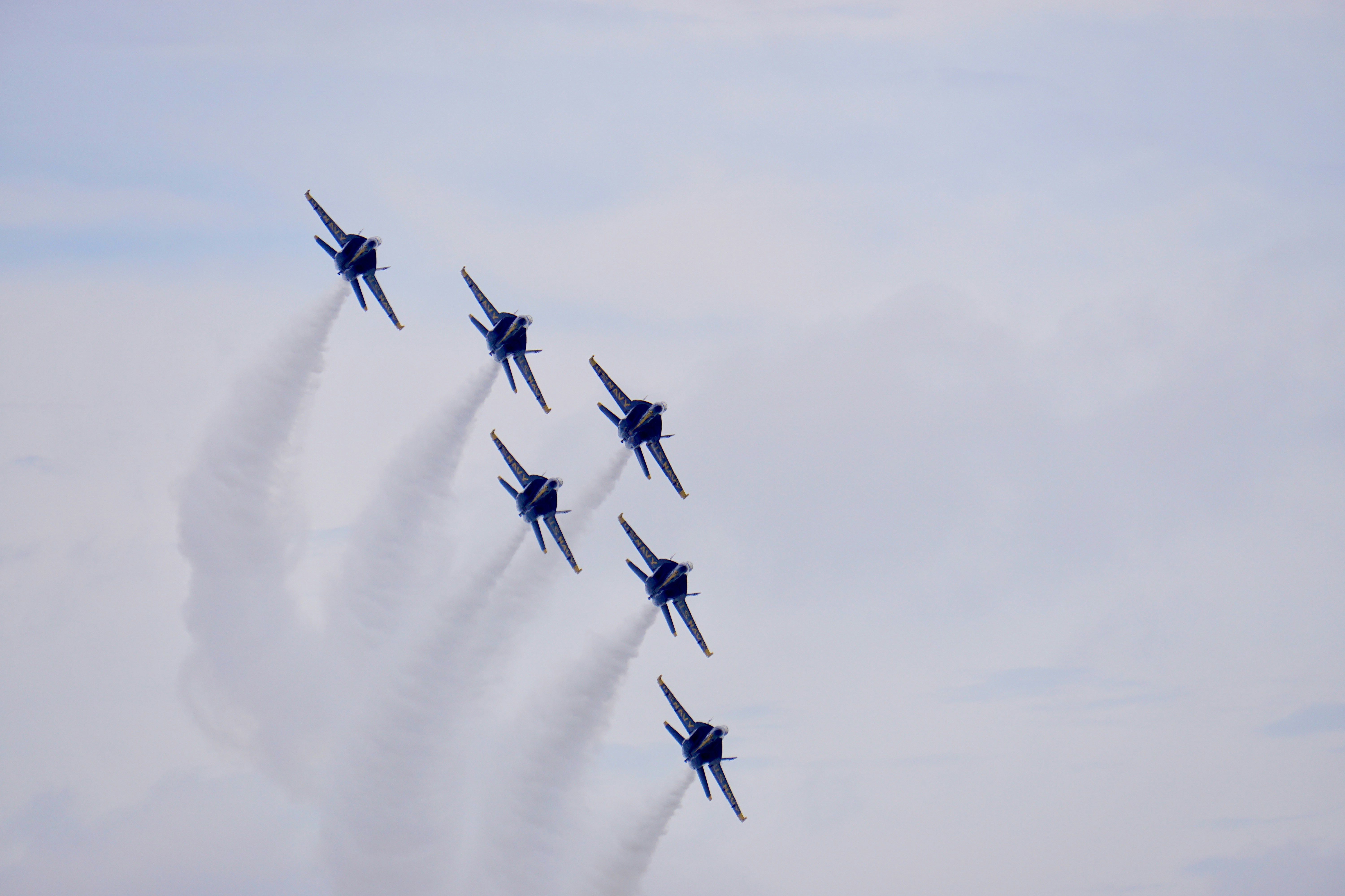 Arc of Six: Aerial Formation Traces a Curved Smoke Line Across the Sky
