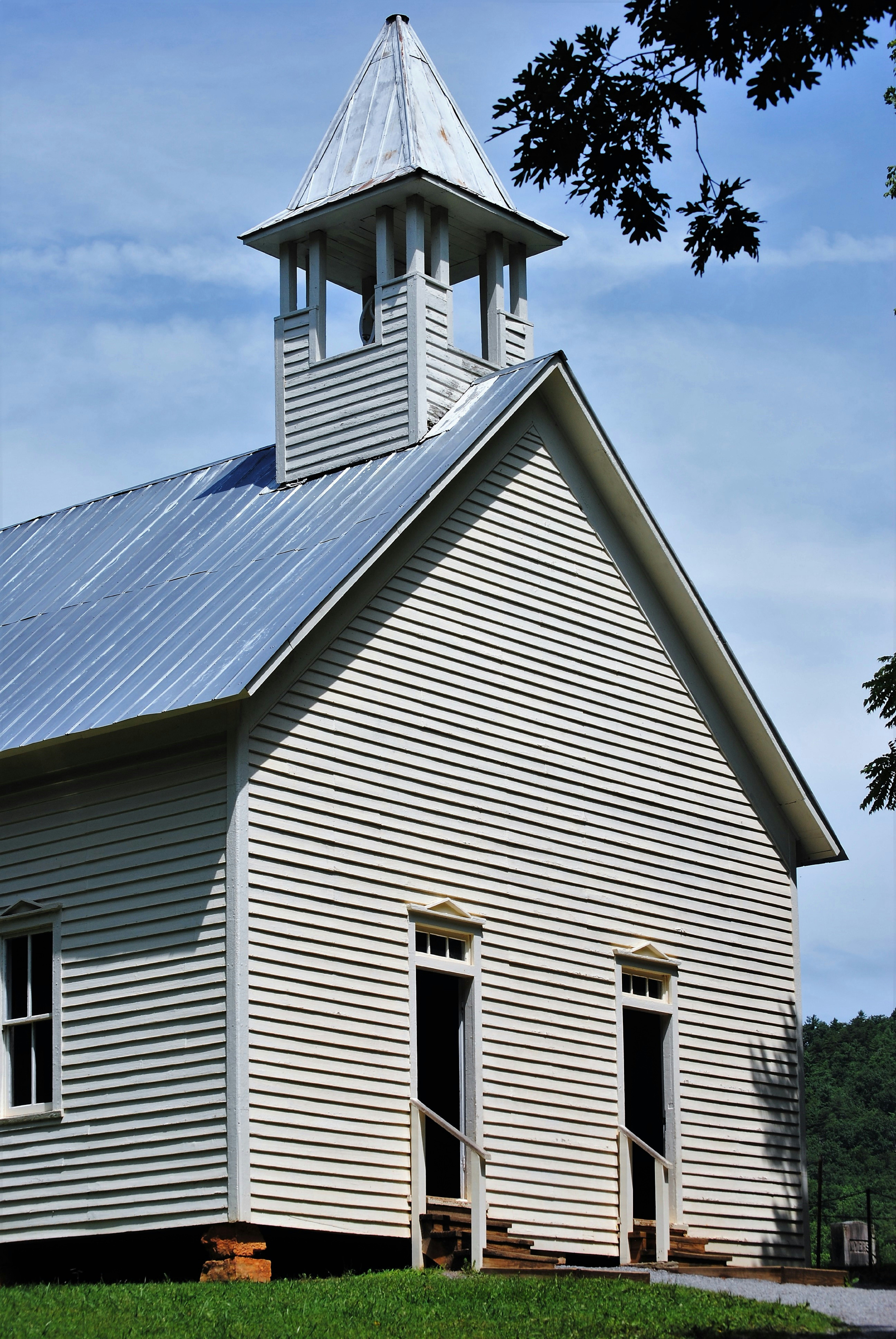 Cupola Crowned Chapel: A White Siding Beacon Under a Clear Sky