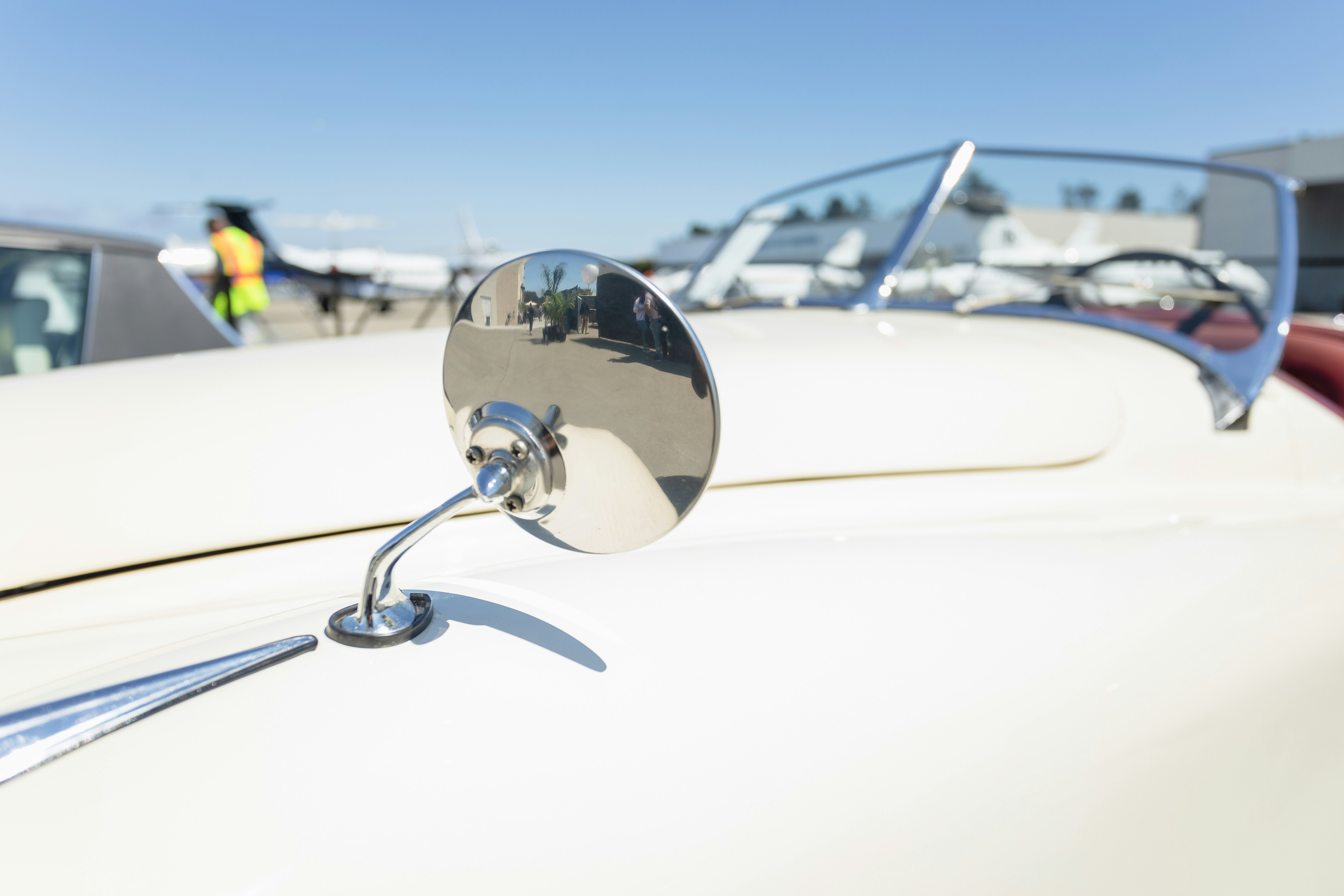 Chrome Compass on Cream: A Vintage Convertible at the Car Show