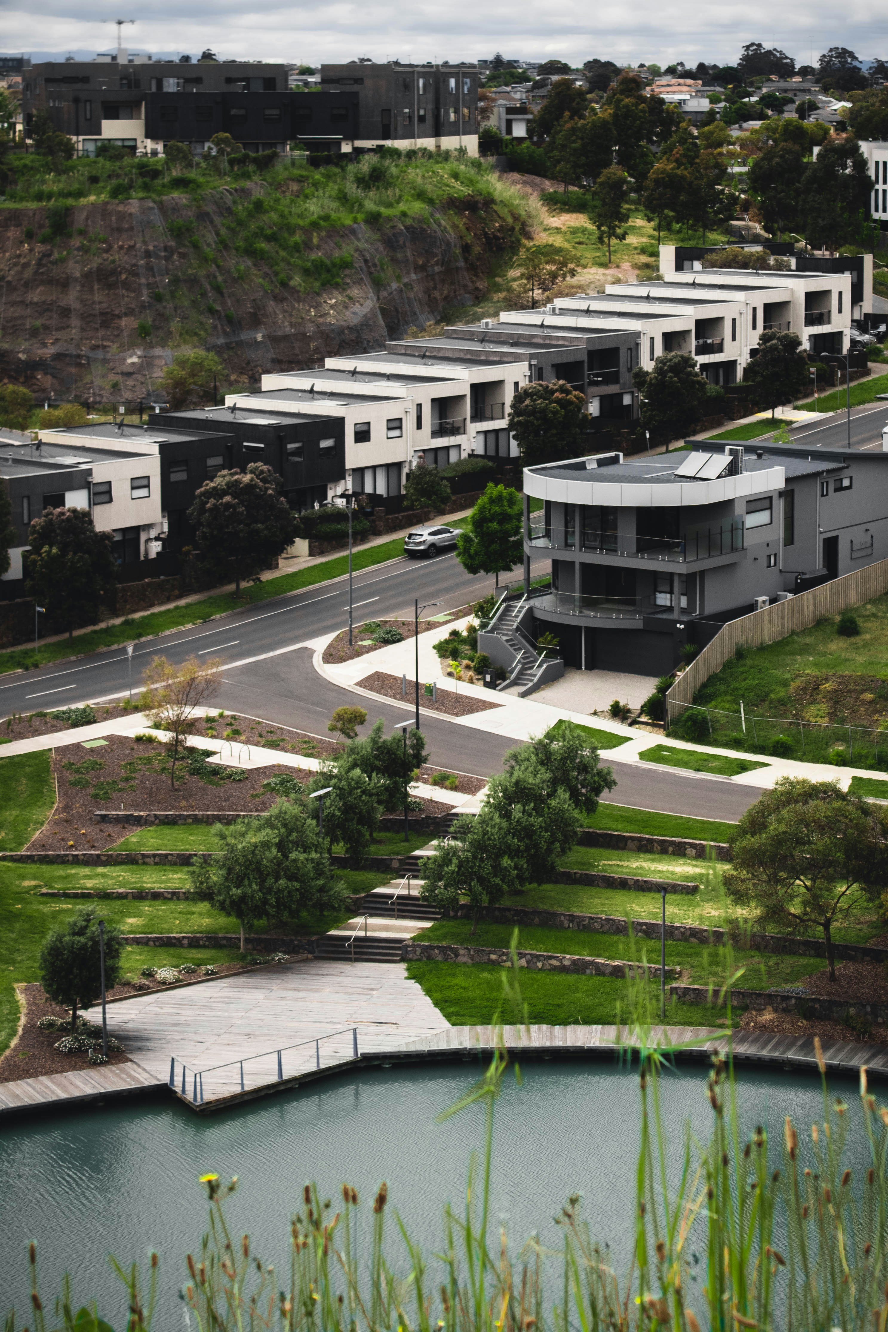 Curved Facades over Green Corridors: A Hillside Townhouse Ensemble