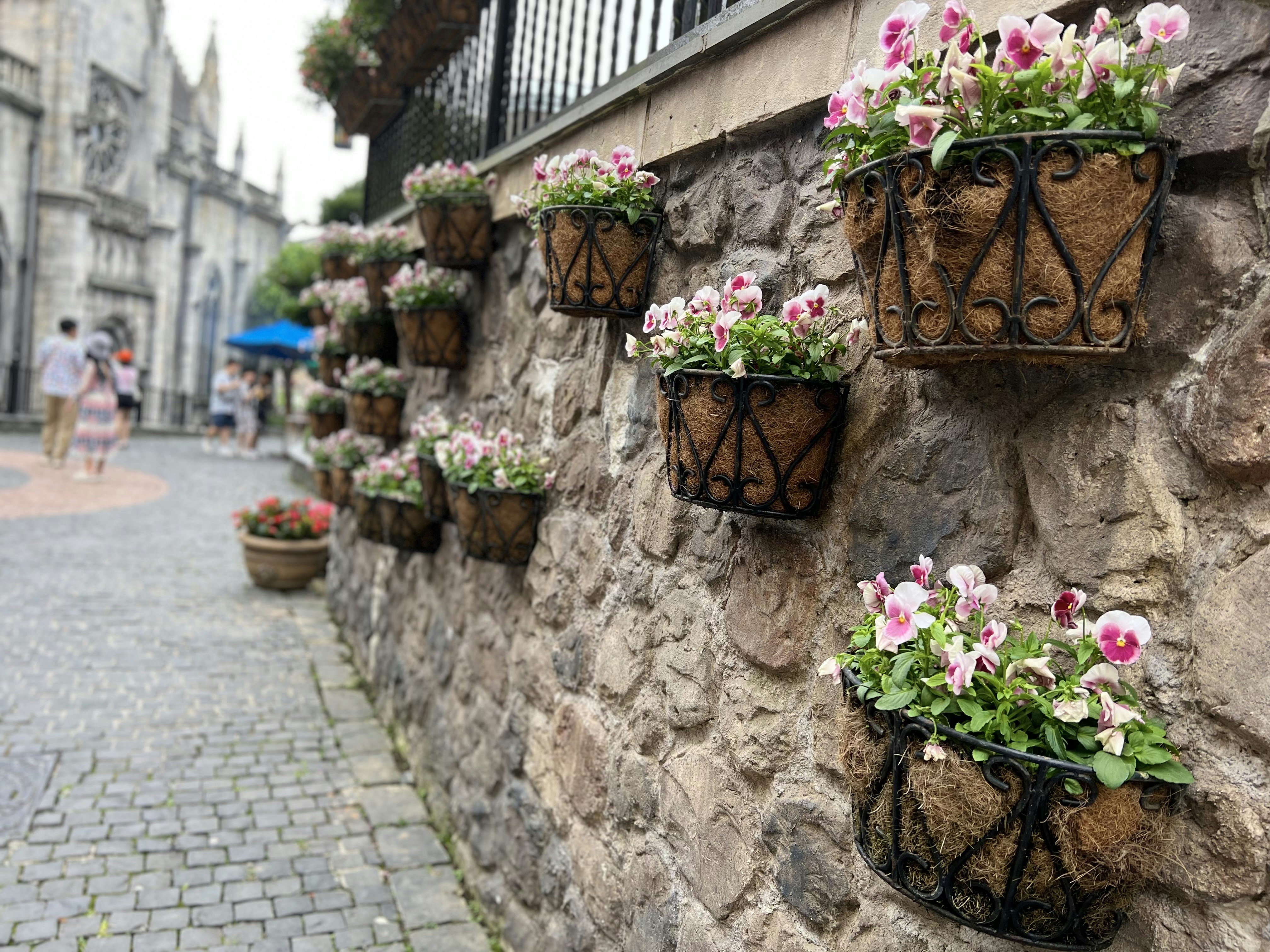 a stone wall with flowers and baskets on it