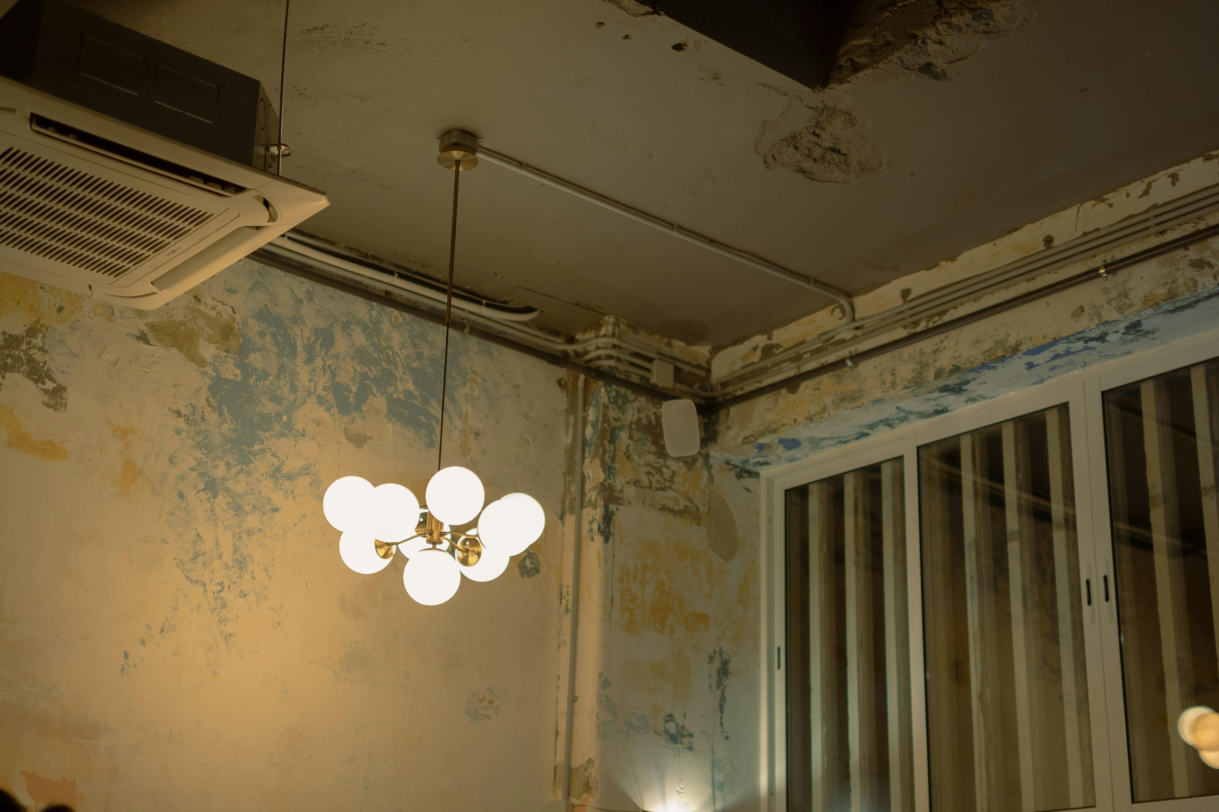 Orbs Against Weathered Blue: A Minimal Chandelier in a Loft of Peeling Paint