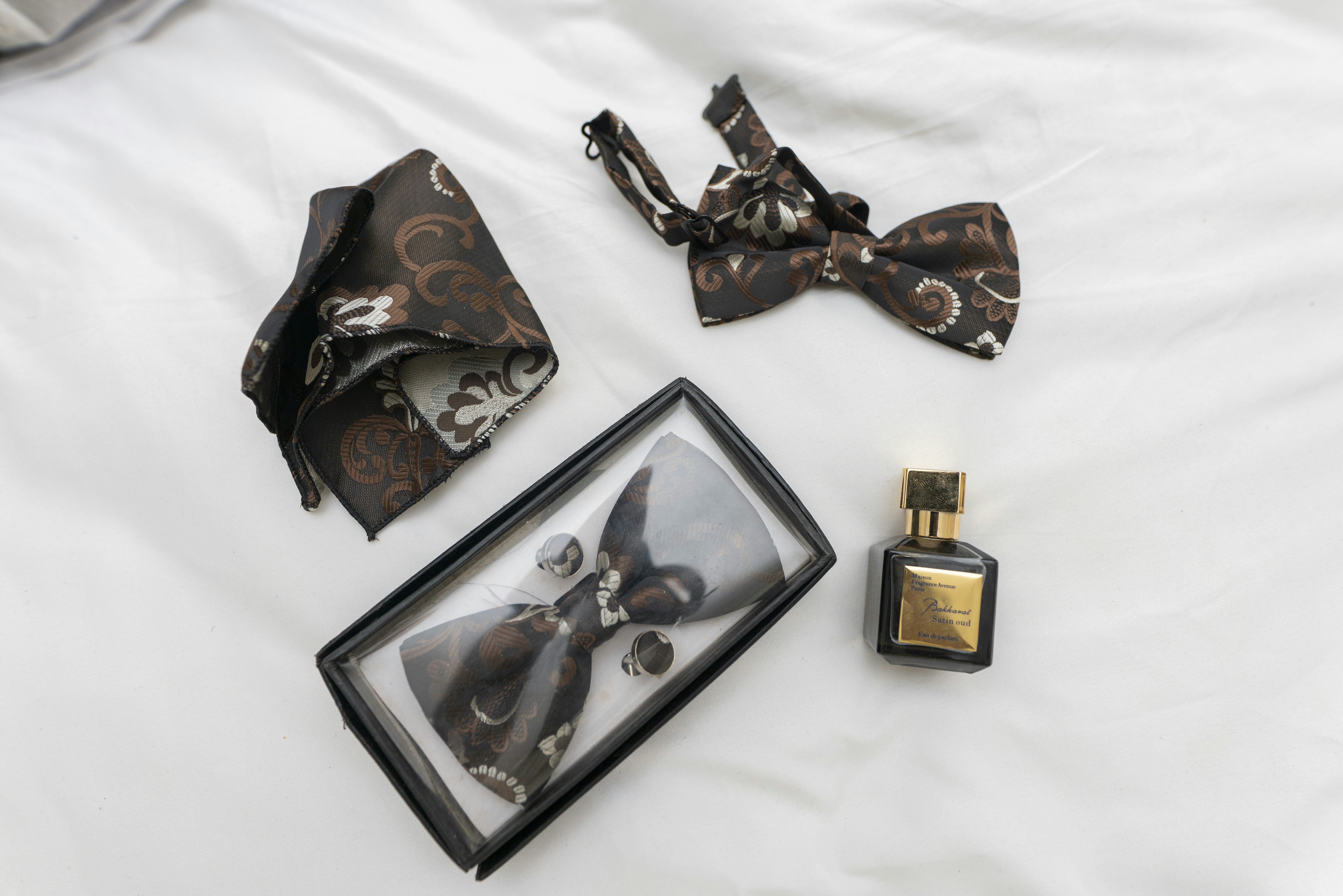 Satin Bowties and a Glass Case: A Quiet Still-Life on White Linen