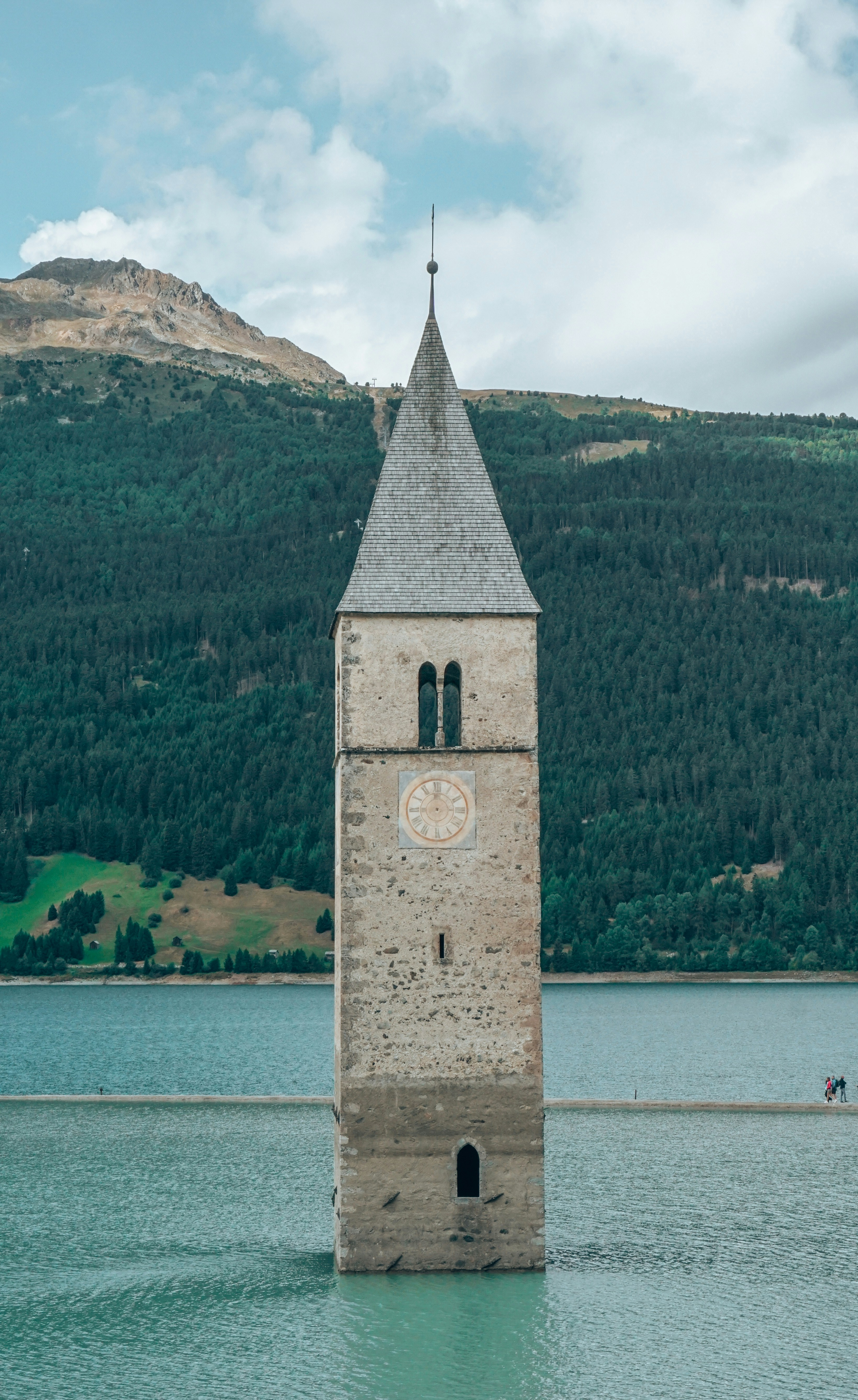 Tower in Water: A Lone Spire Rising from Lake Brimming with Mountains