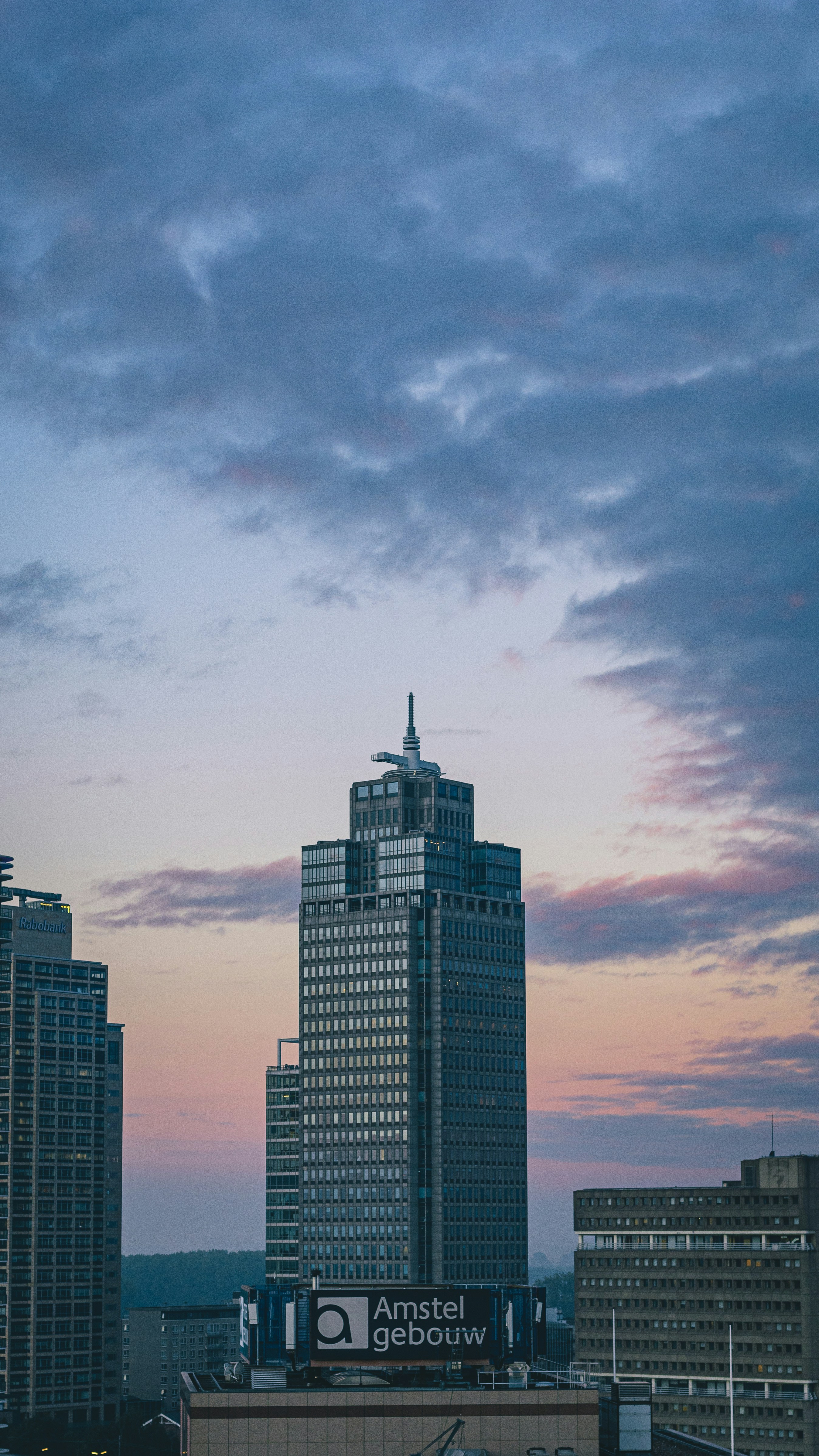 A tall building with a sign in front of it photo – Free Building Image ...