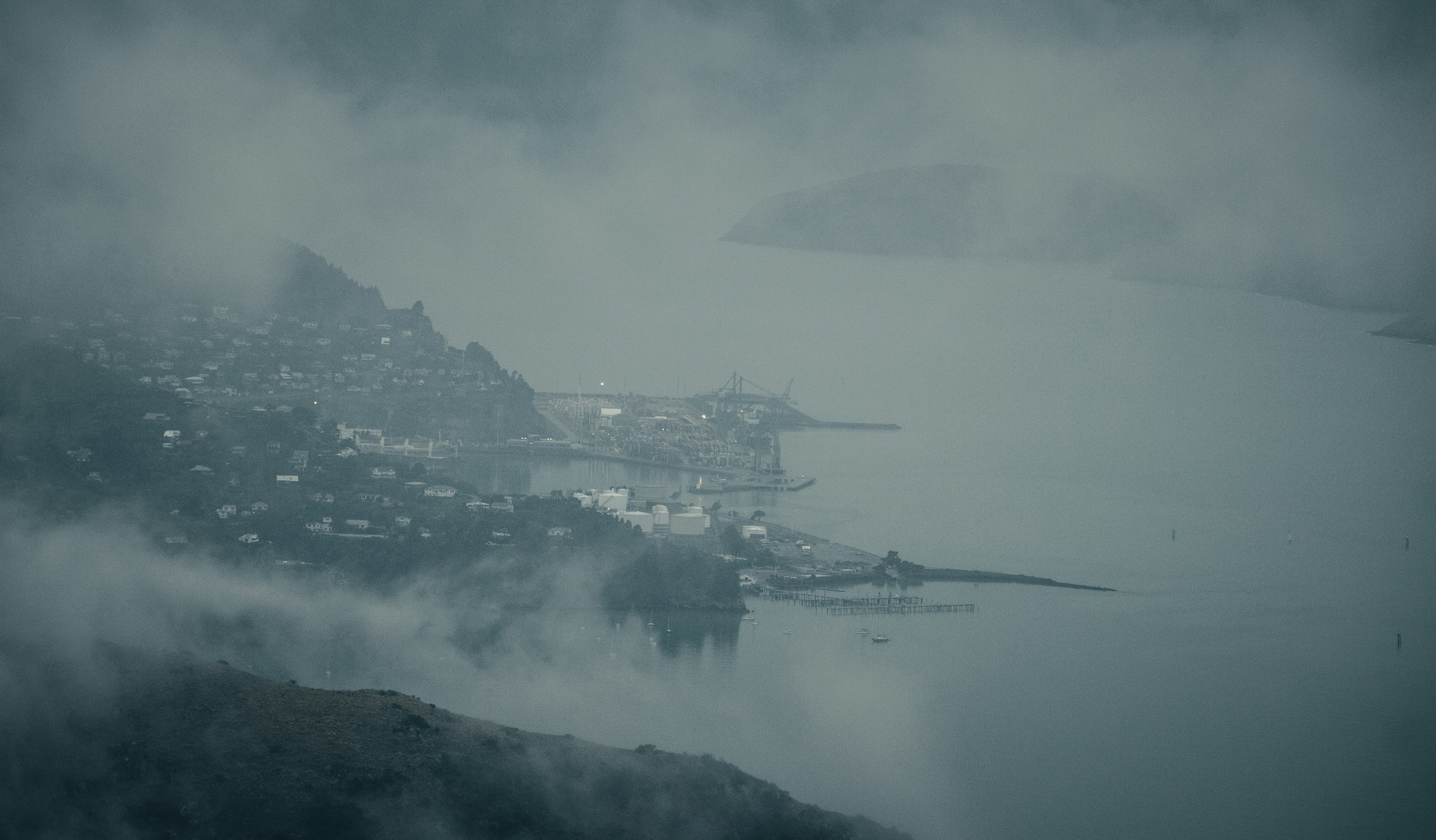 Mist-Locked Harbor: A Coastal Town Veiled in Blue Fog
