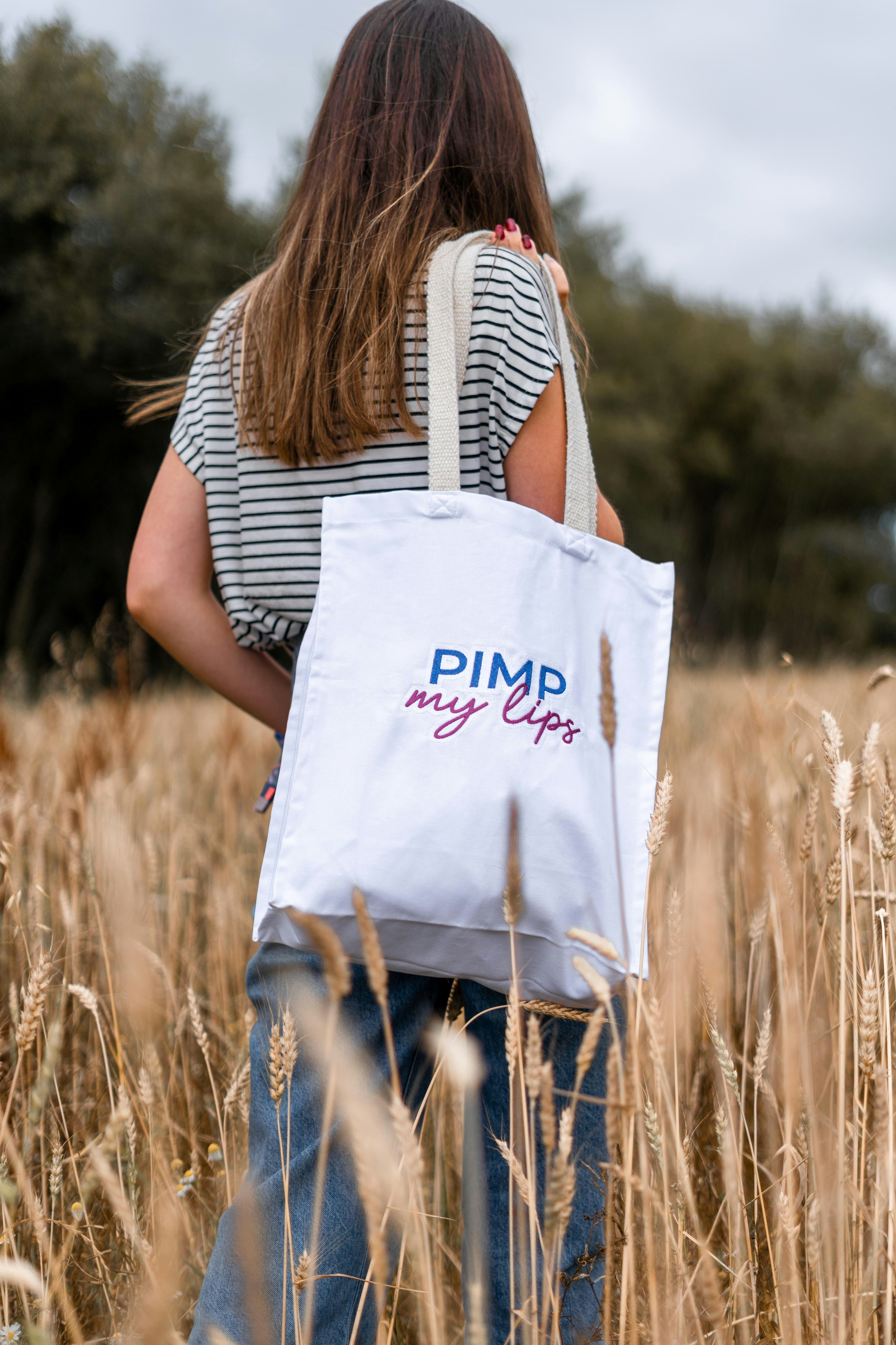 Field Portrait: A White Tote with Bold Lip Branding in Golden Grass