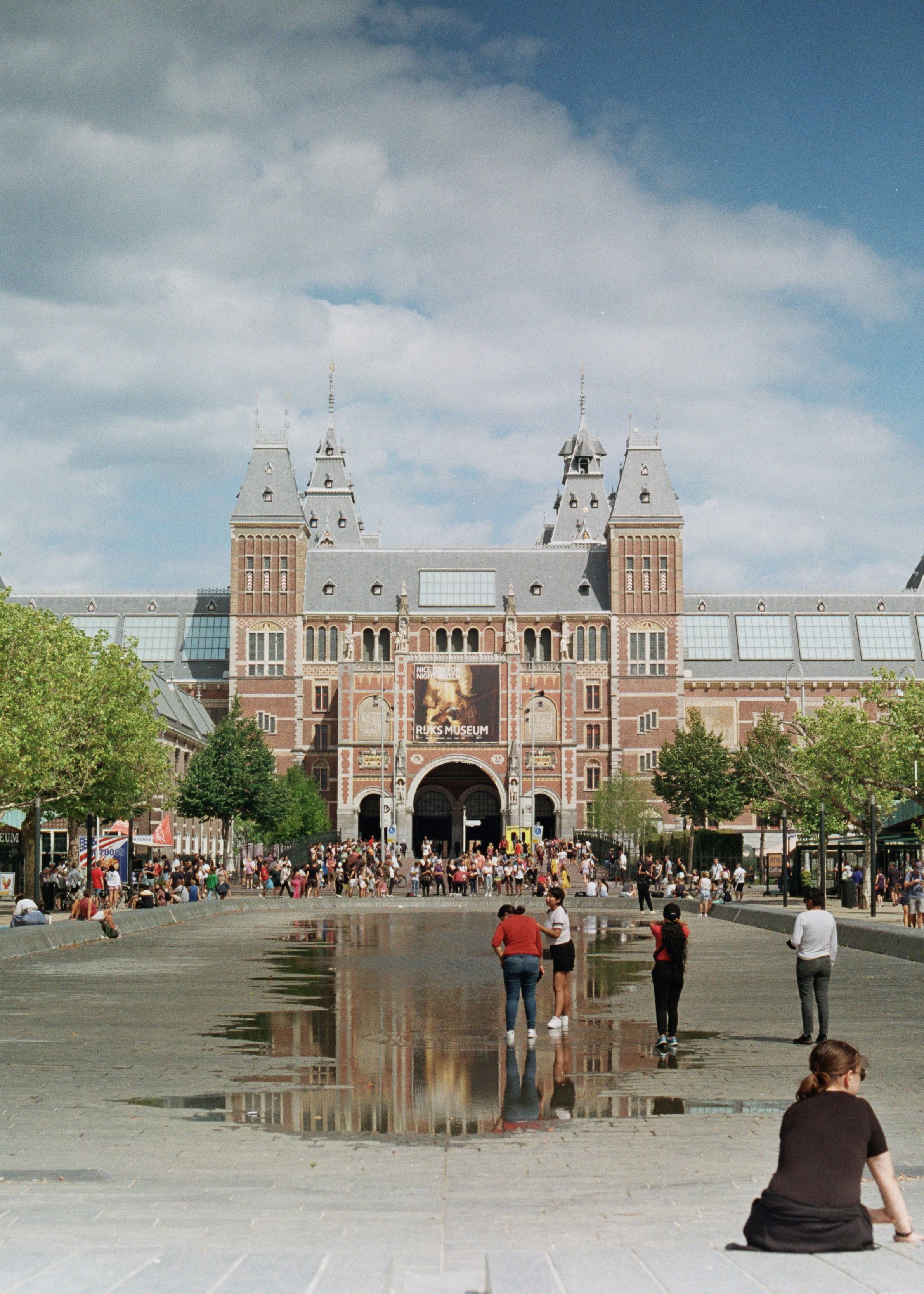 A group of people walking around a large building photo – Free ...