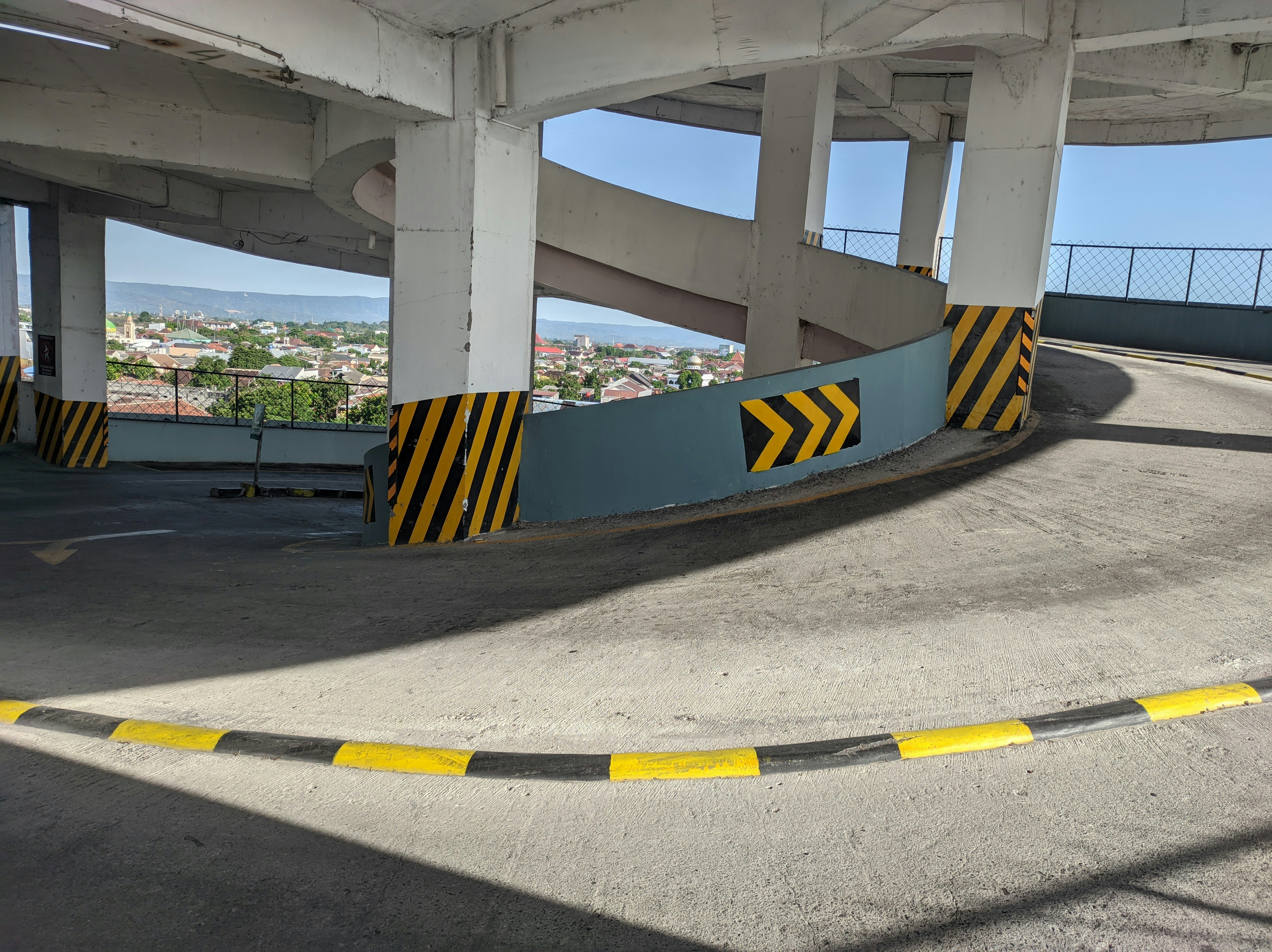 Sunlit Curve: A Parking Deck Frame Framing a Distant City