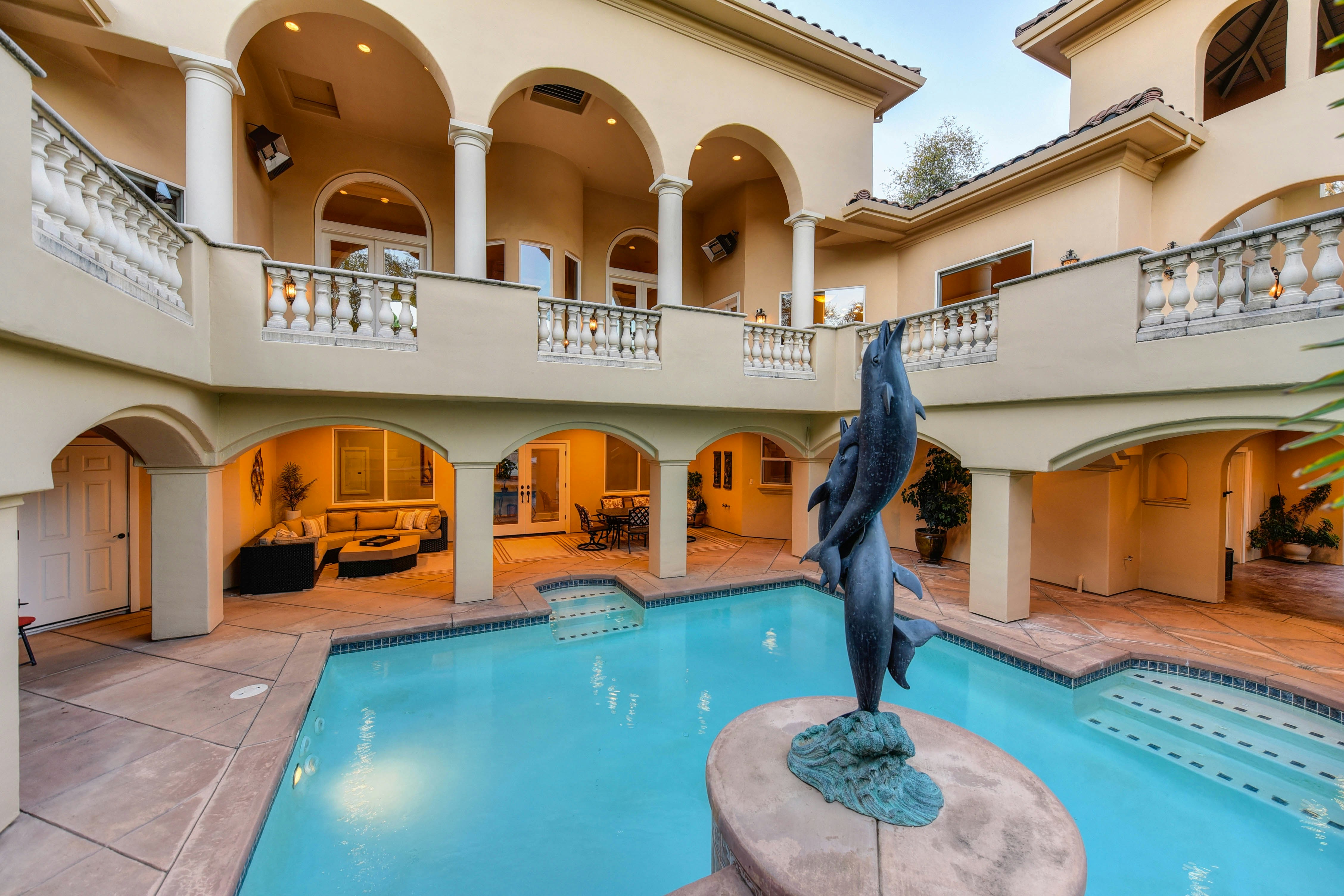Courtyard Oasis: Statues near the Teal Pool under Arched Walkways