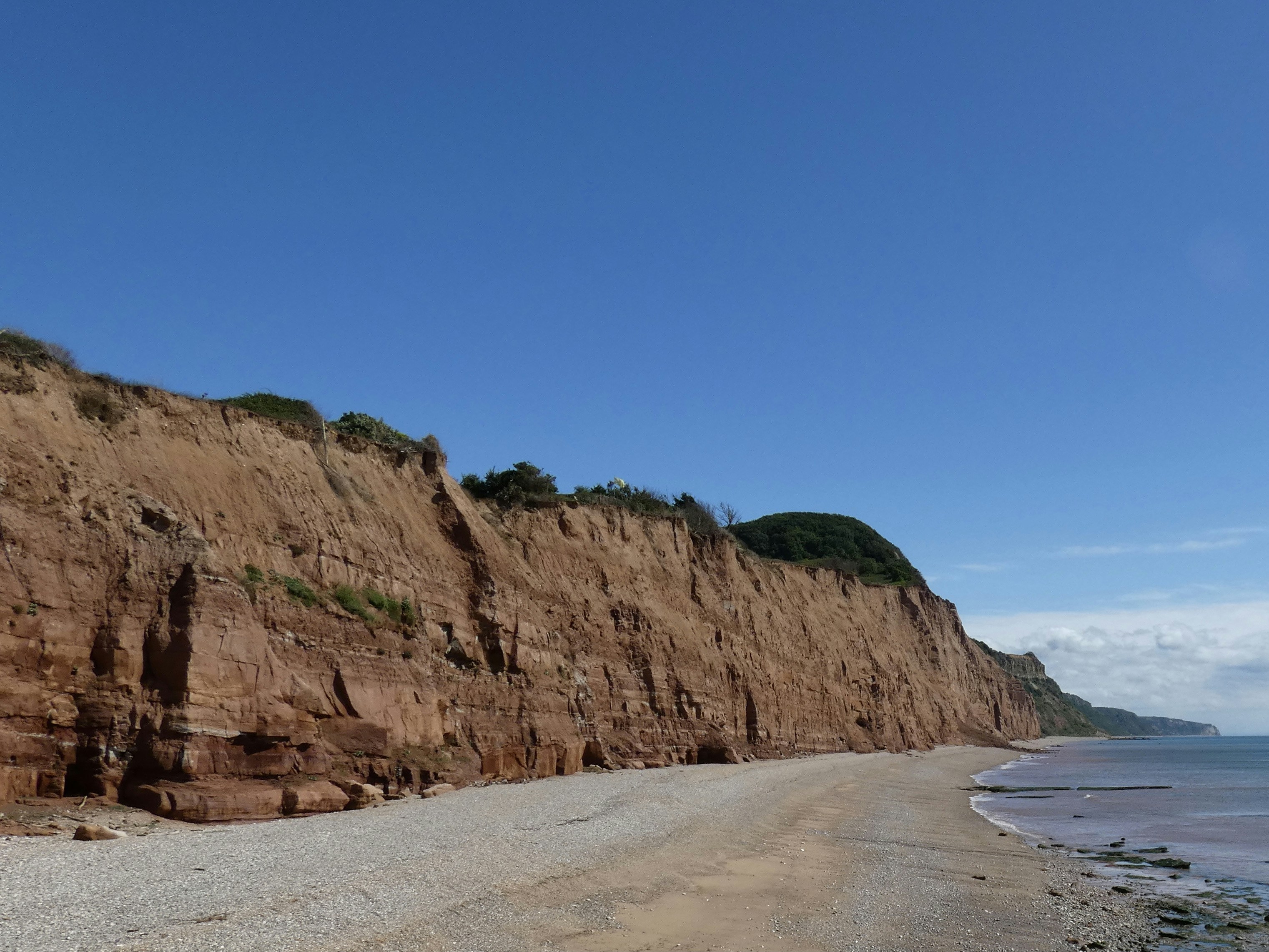 A rocky cliff next to a beach with Calvert Cliffs State Park in the ...