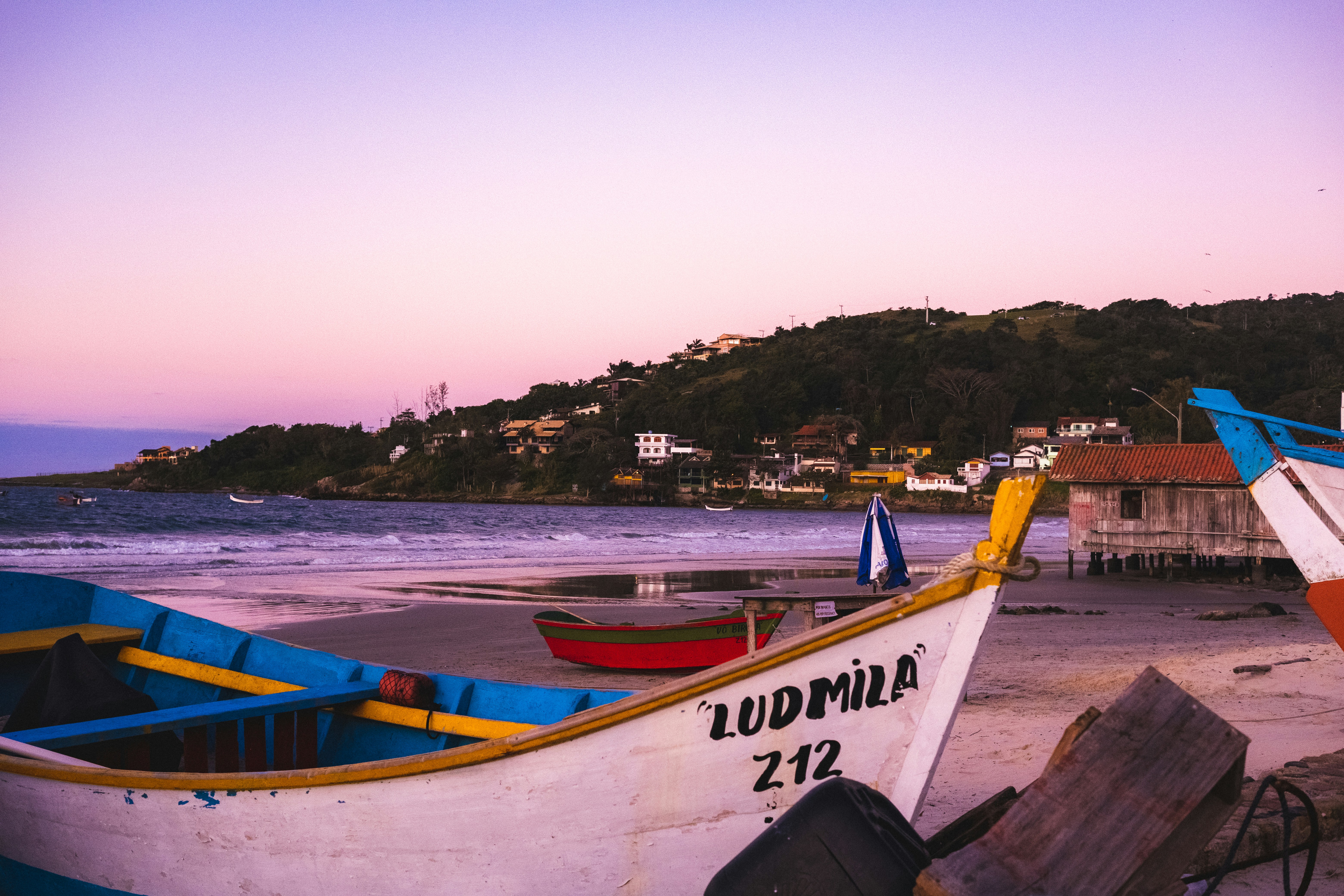 Sunset on the Shore: Colorful Boats Rest in Quiet Light