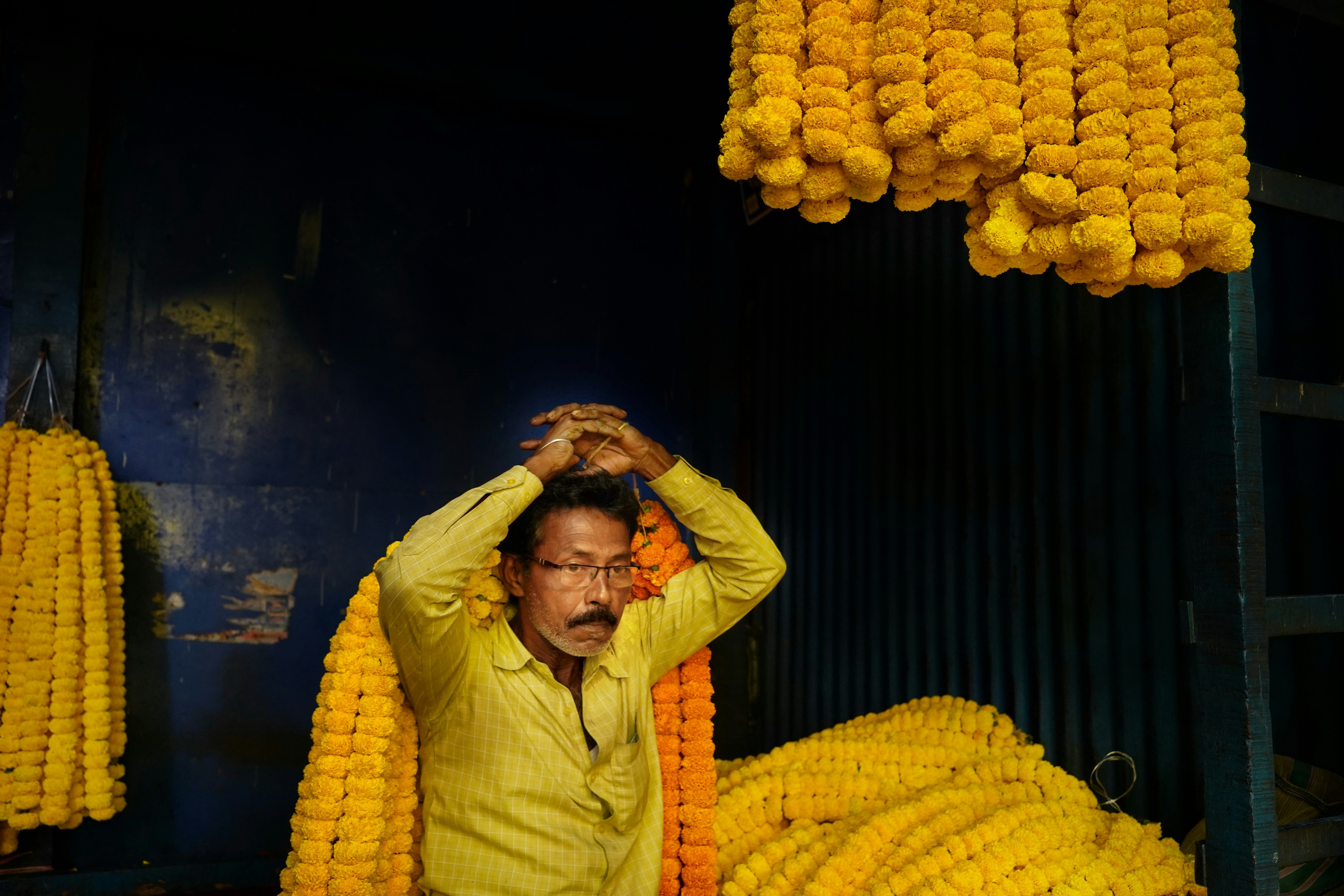 Arms Raised Amid Cascades of Marigold Garlands