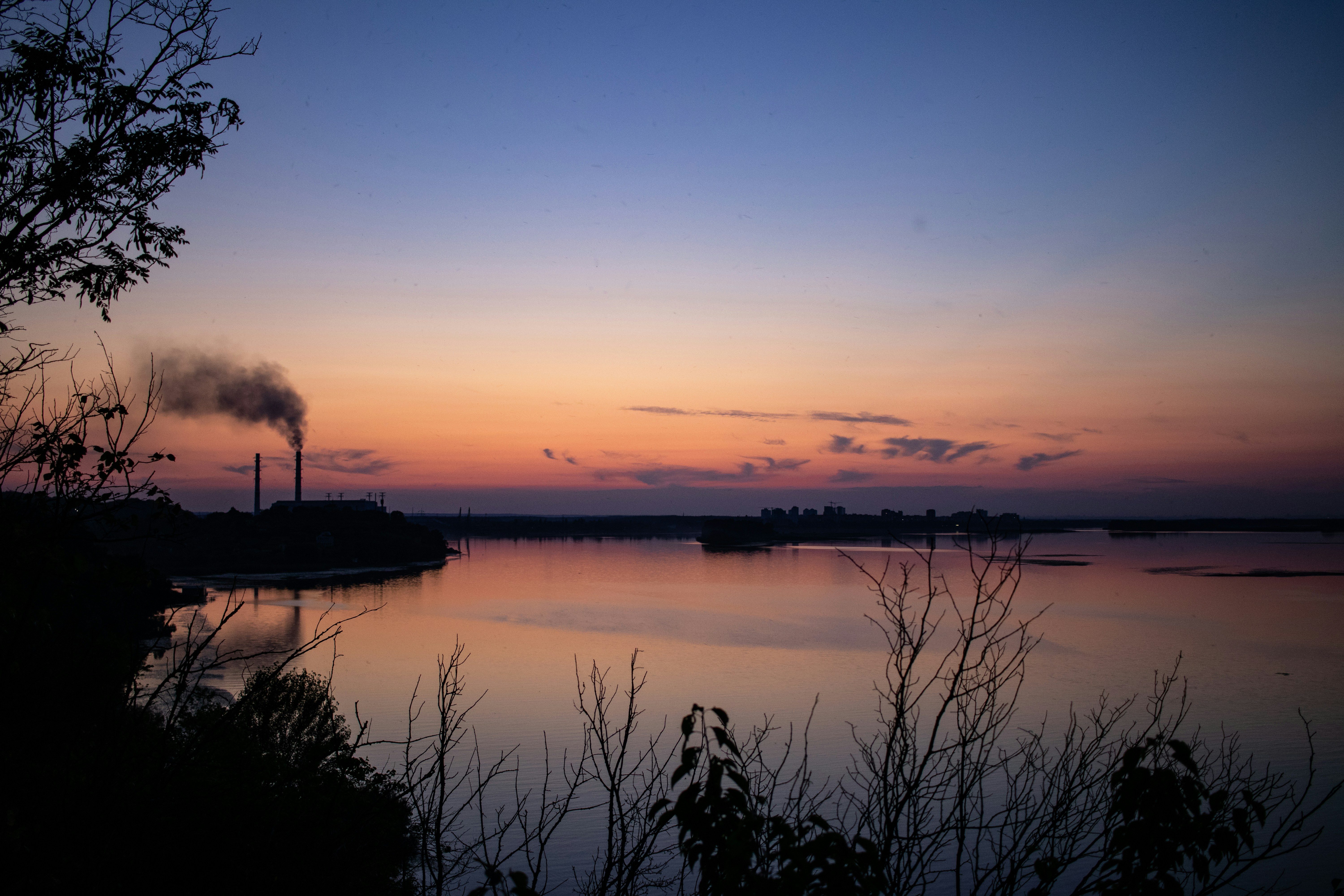 Dusk over the Riverside: Smoke and Silence at Sunset