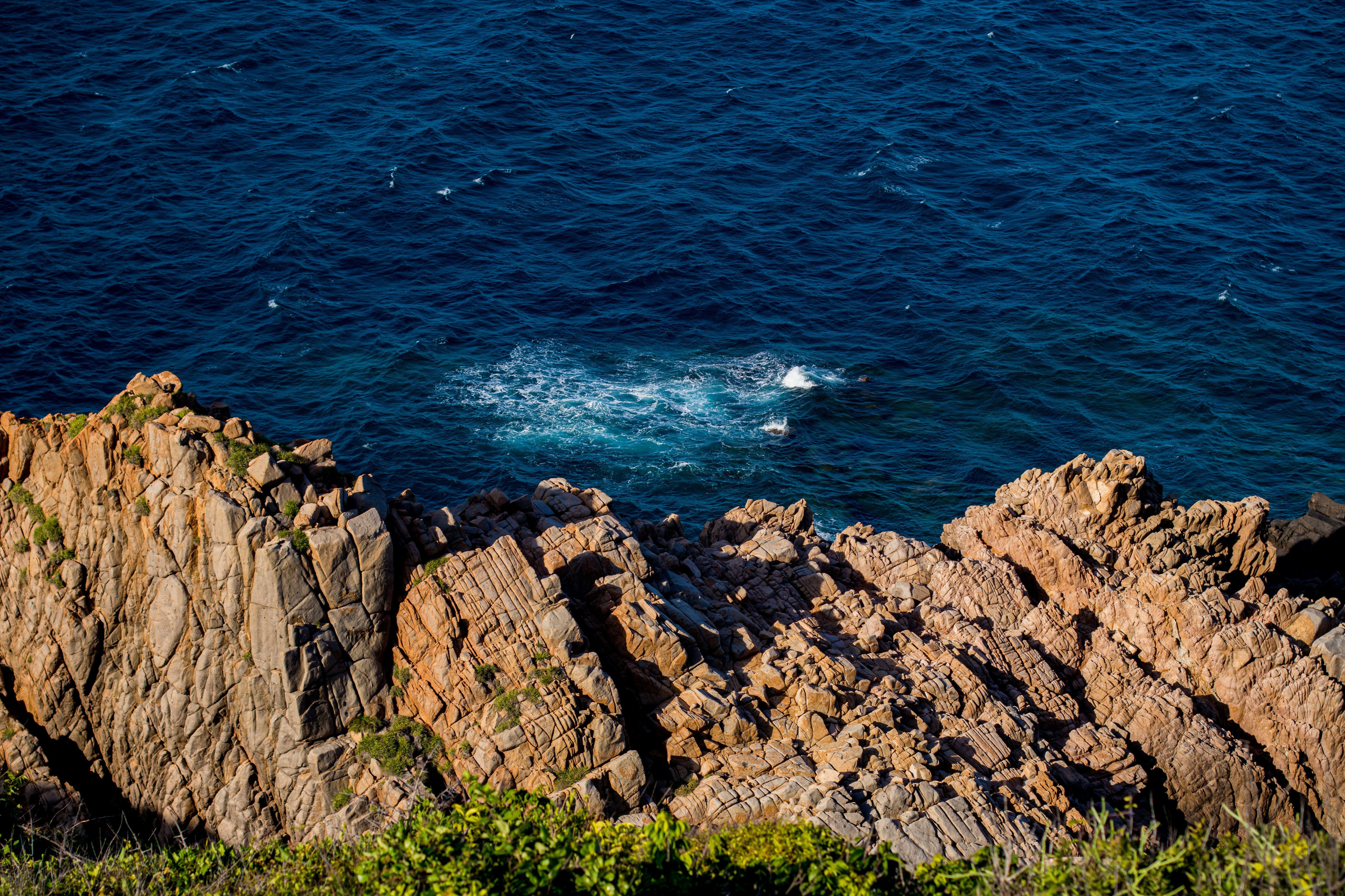 Foto Un acantilado rocoso con un cuerpo de agua en el fondo – Imagen ...