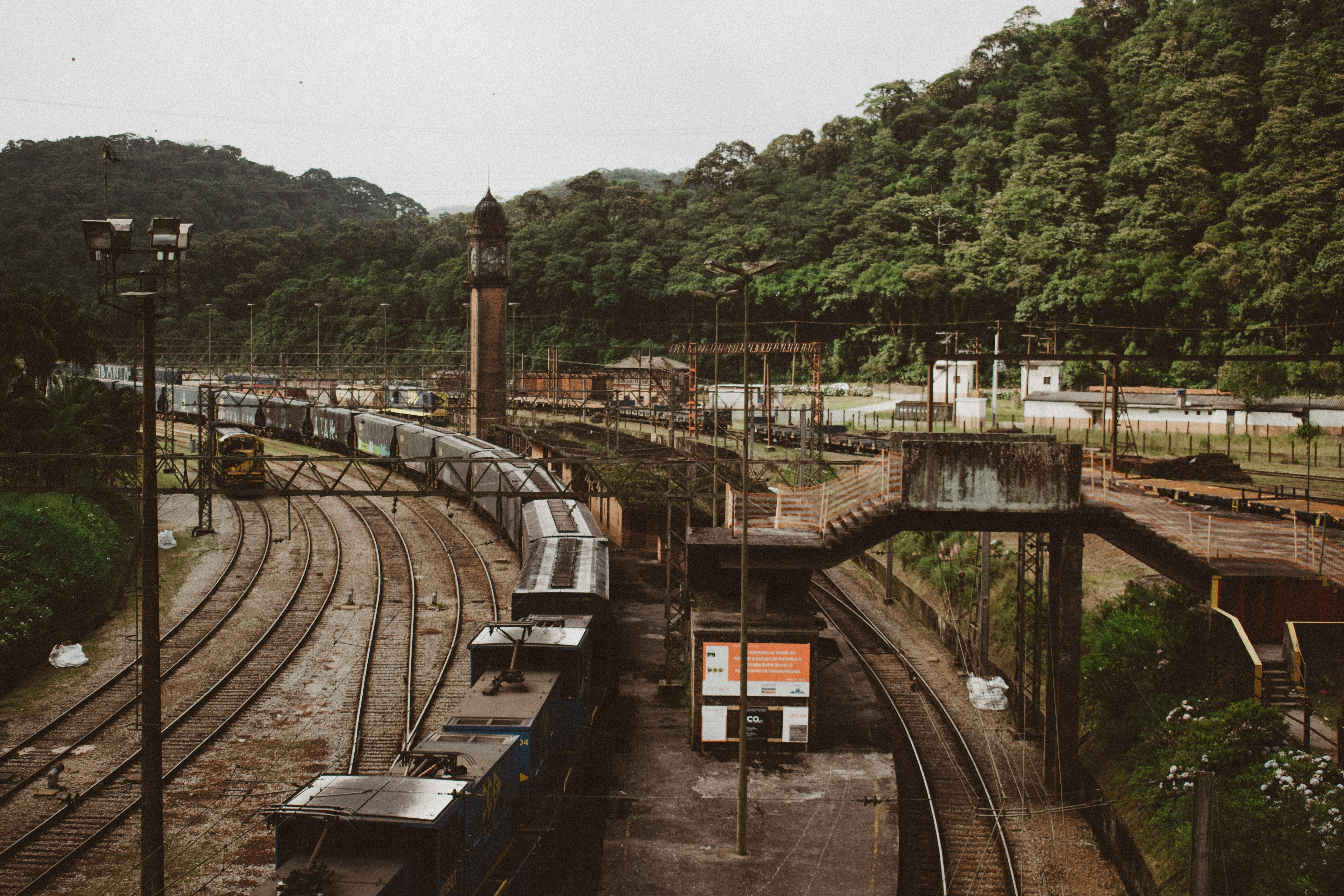 Convergence of Rails in a Quiet Yard Beneath Forested Hills