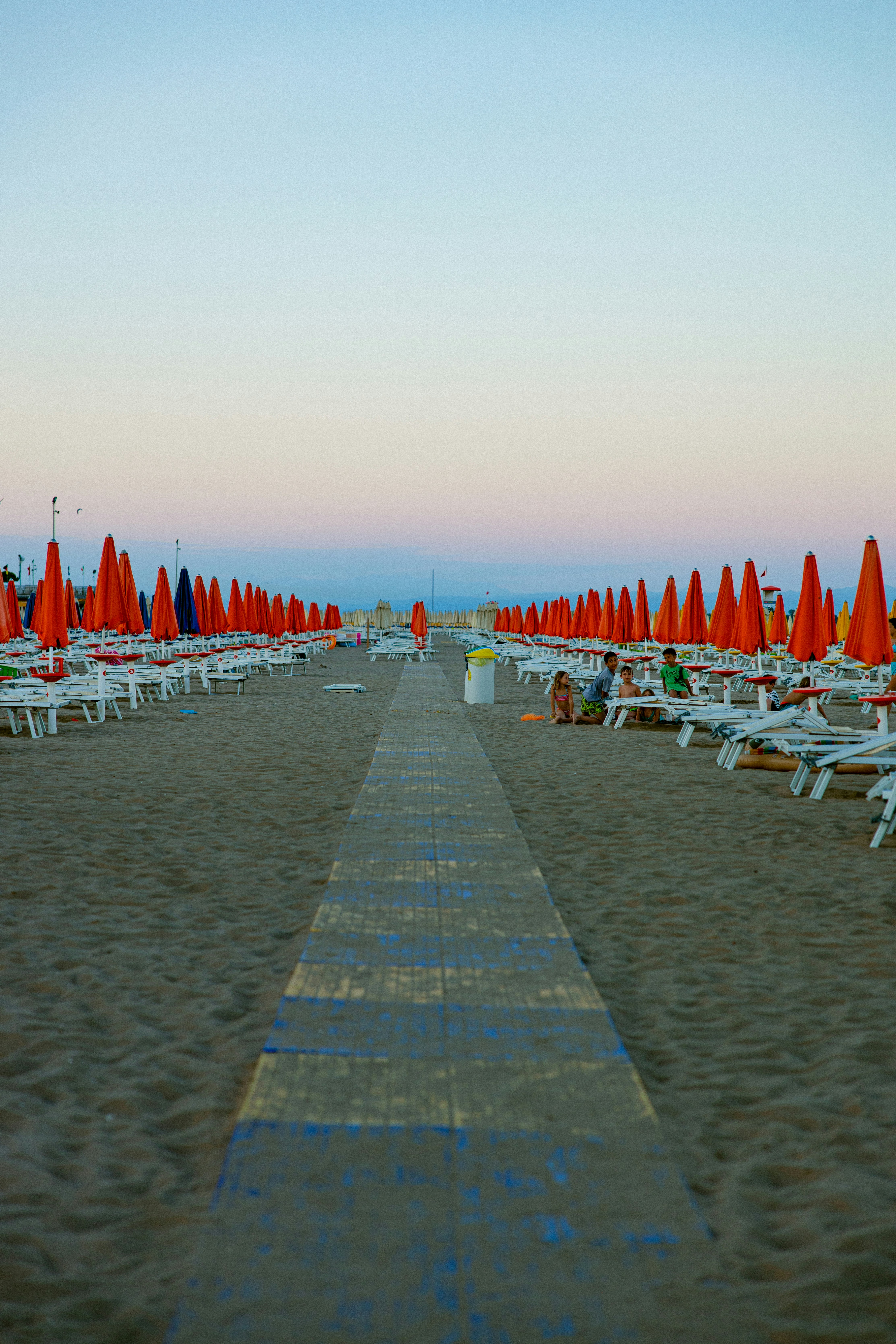 Amber Aisle to the Sea: A Beachfront Walk Through a Corridor of Orange Umbrellas