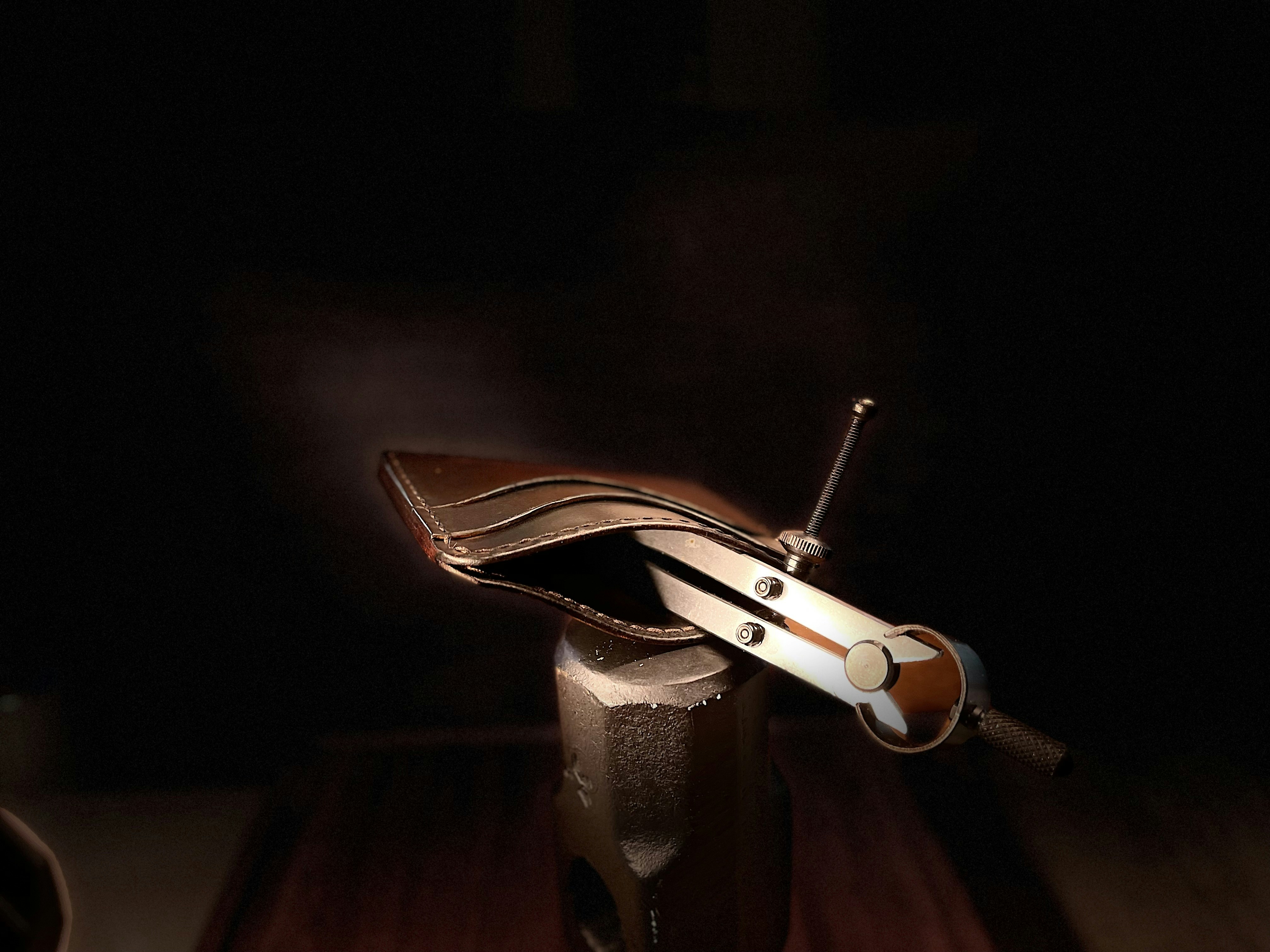 Copper-Trimmed Pocket Knife Resting on Warm Wood Under Amber Glow