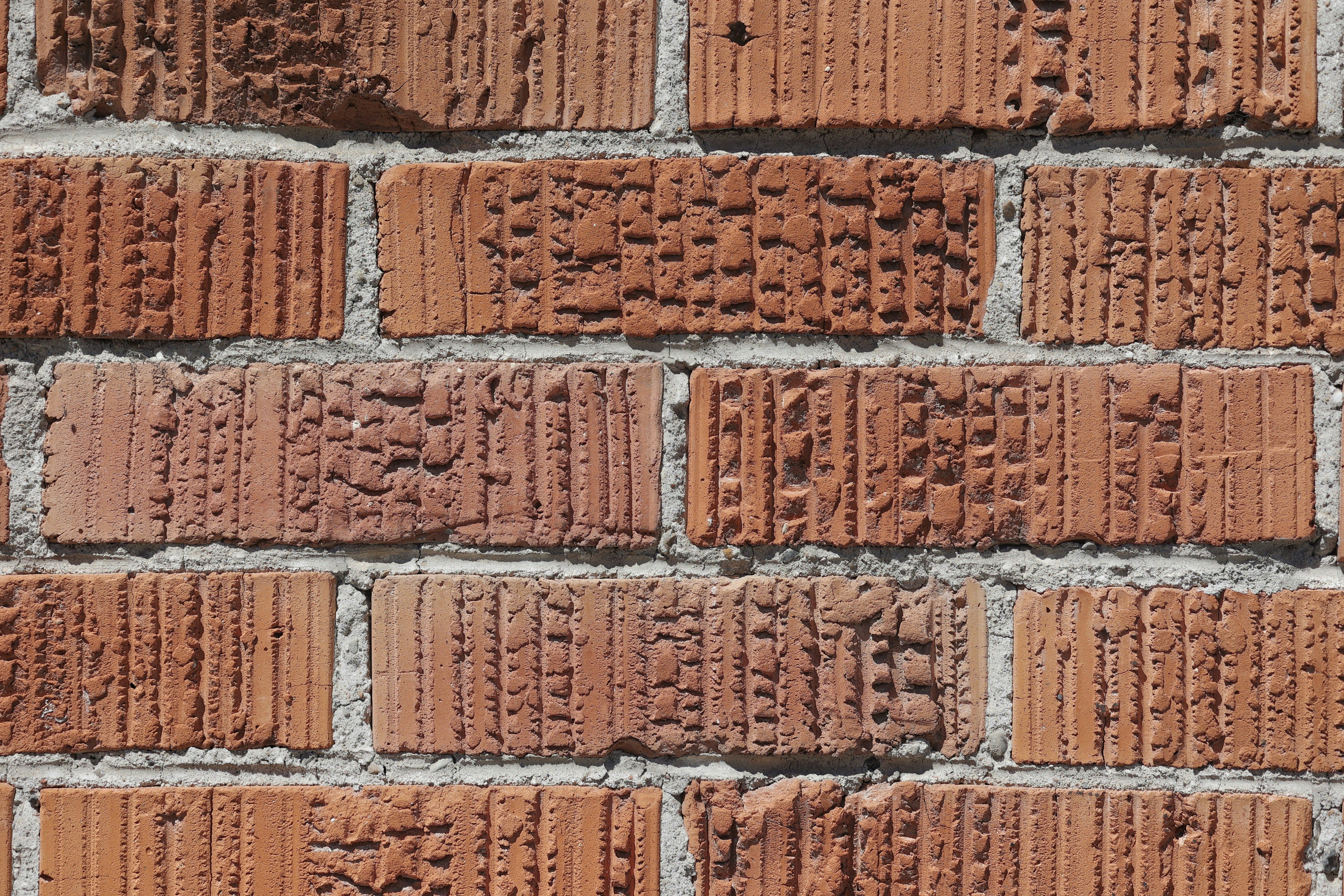 Close-up view of a brick wall showcasing the intricate textures and patterns of the bricks. The warm hues and uneven surfaces create a rich, tactile experience.